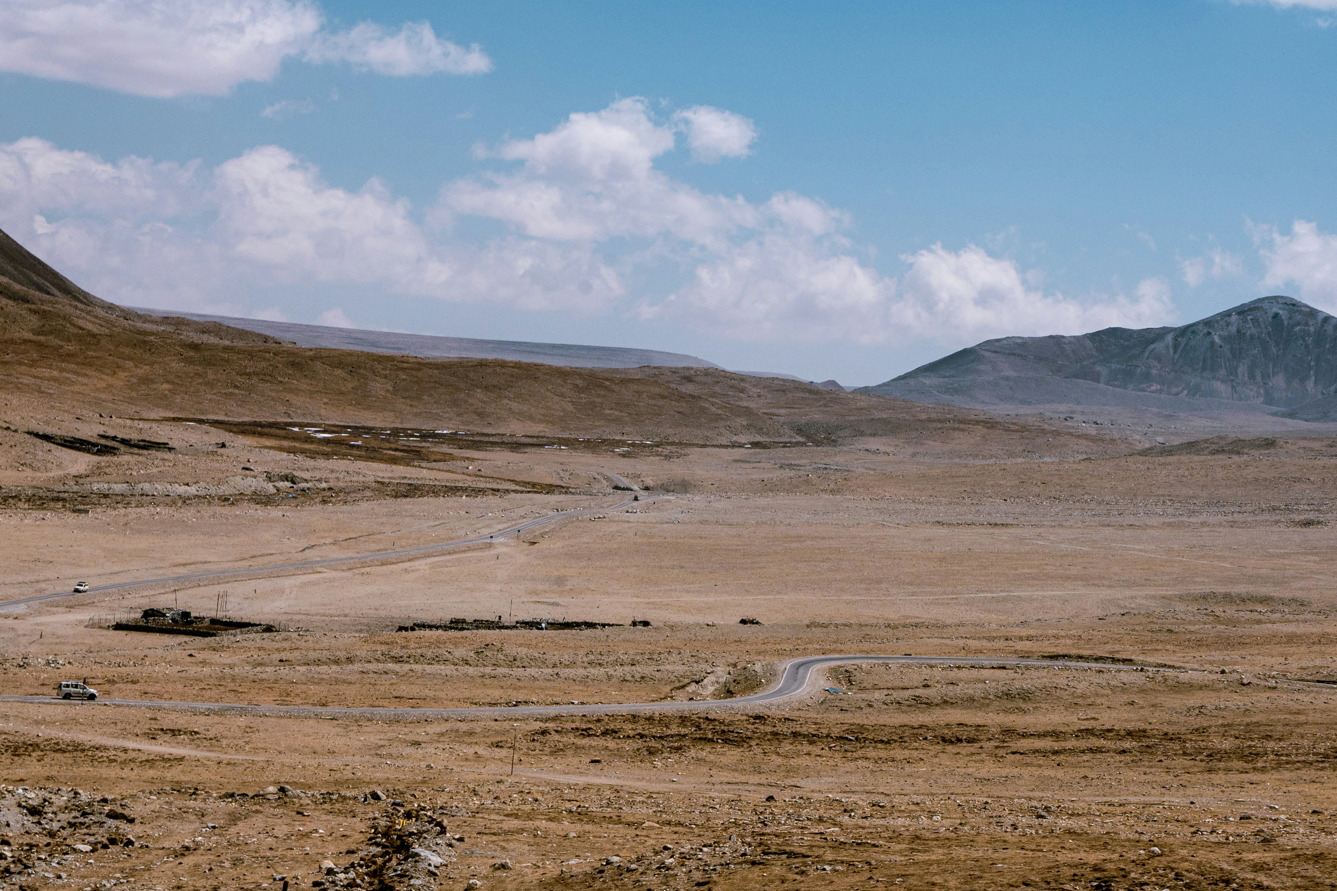 Deserted Rim: A Quiet Road meandering toward distant hills under a vast sky