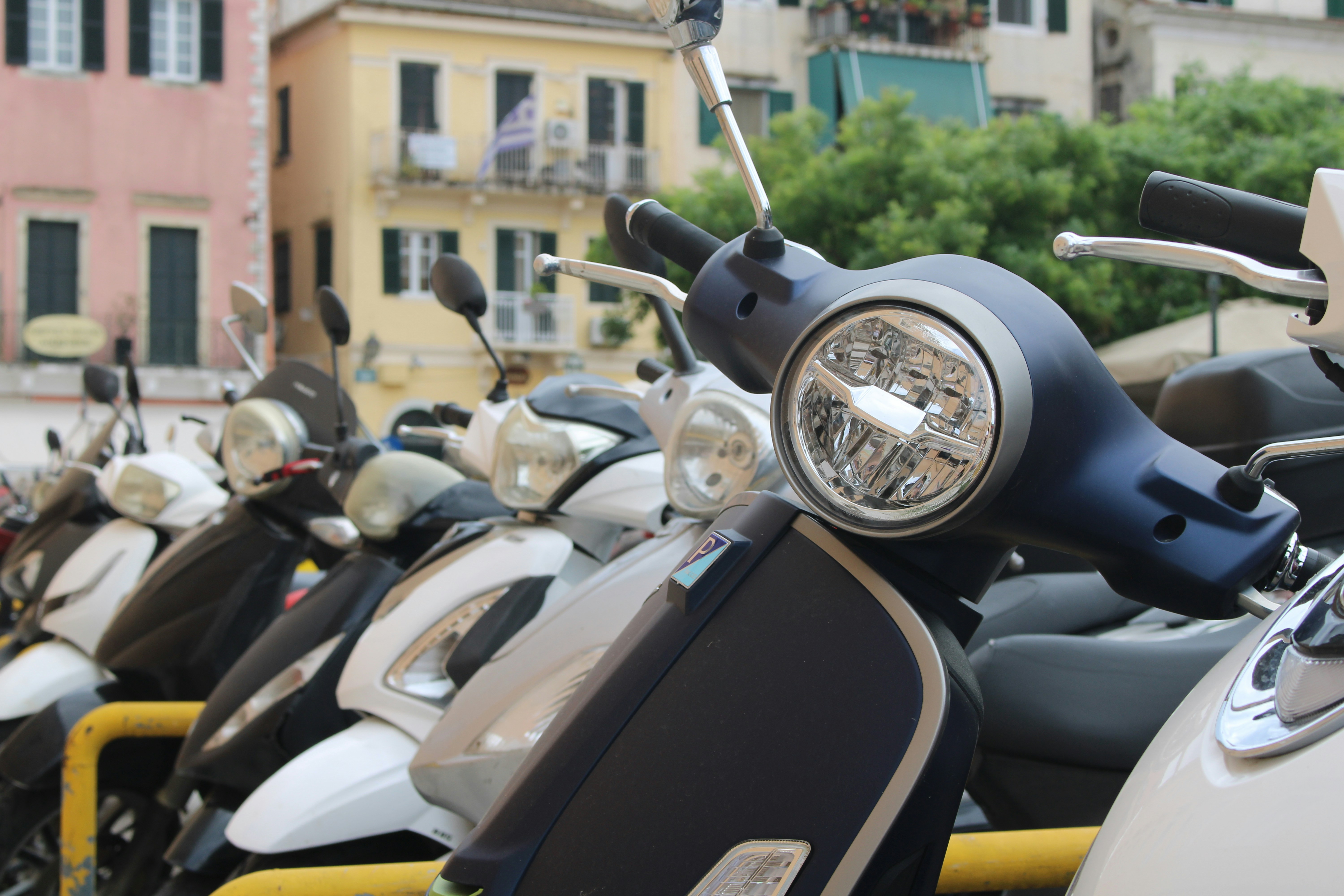 Row of vintage scooters awaiting customers in a sunlit piazza