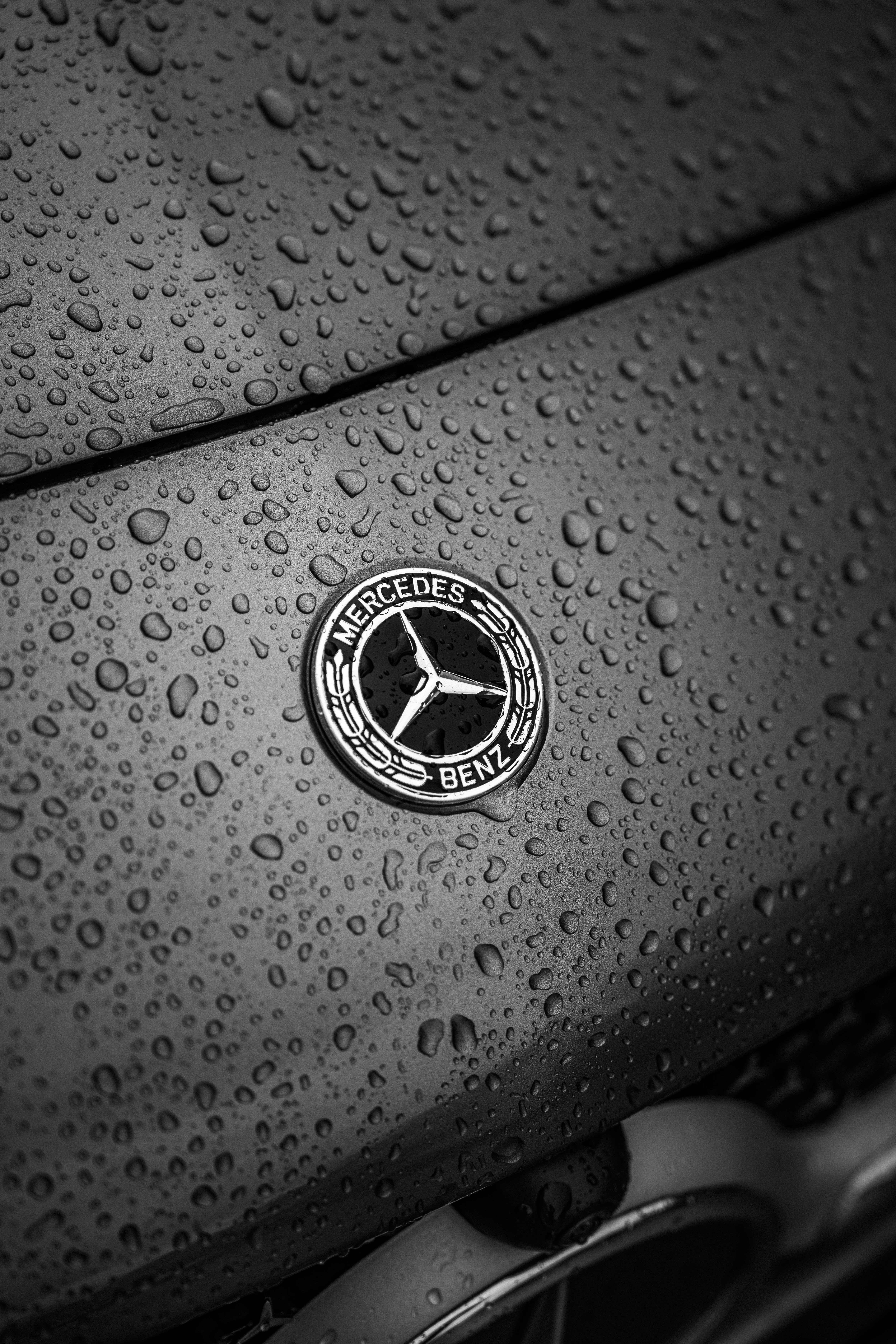 Liquid Armor: A Mercedes-Benz Emblem Centered in Rain-Kissed Metal
