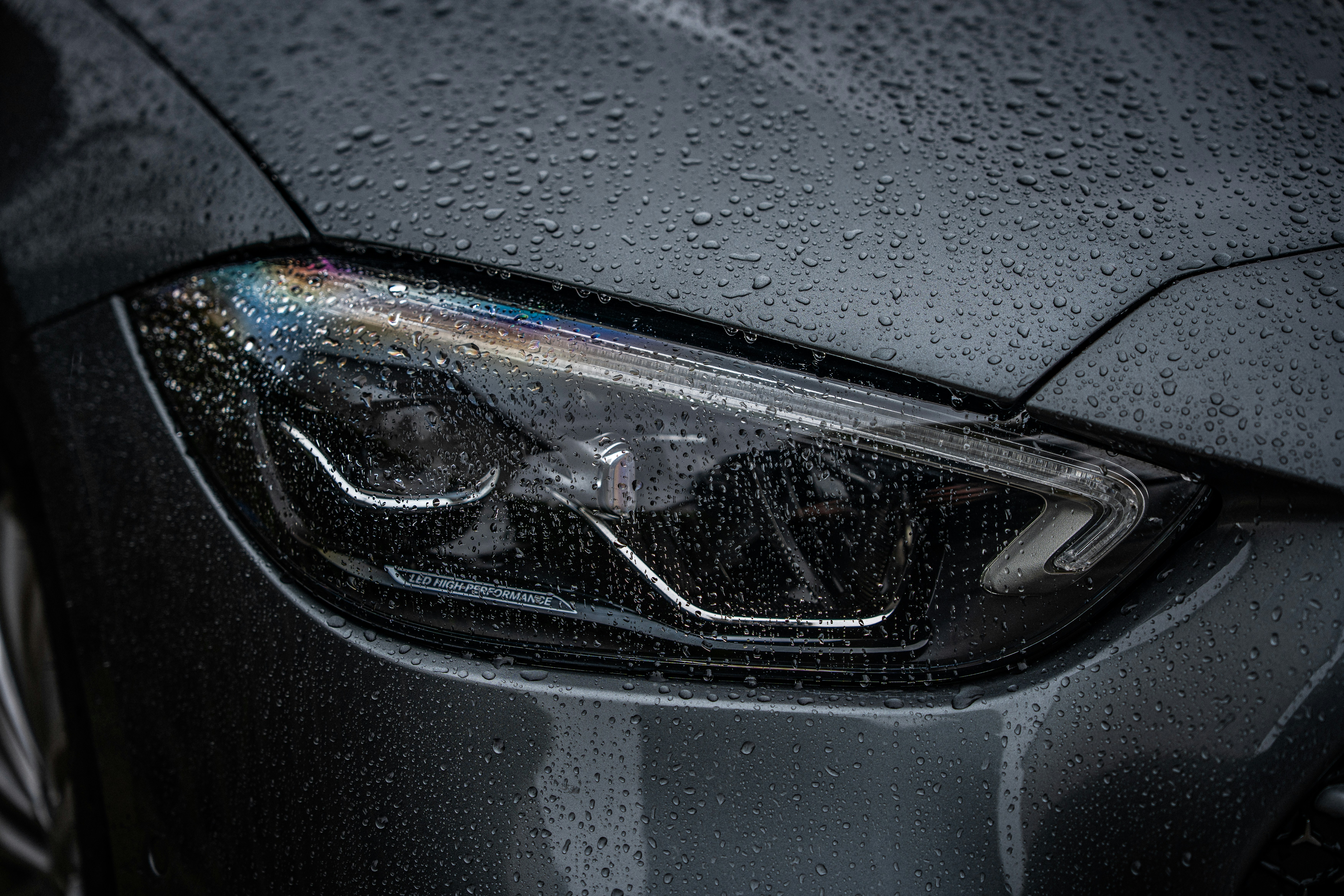 Raindrops on a Metallic Eye: A Close-Up of the Headlamp Hues