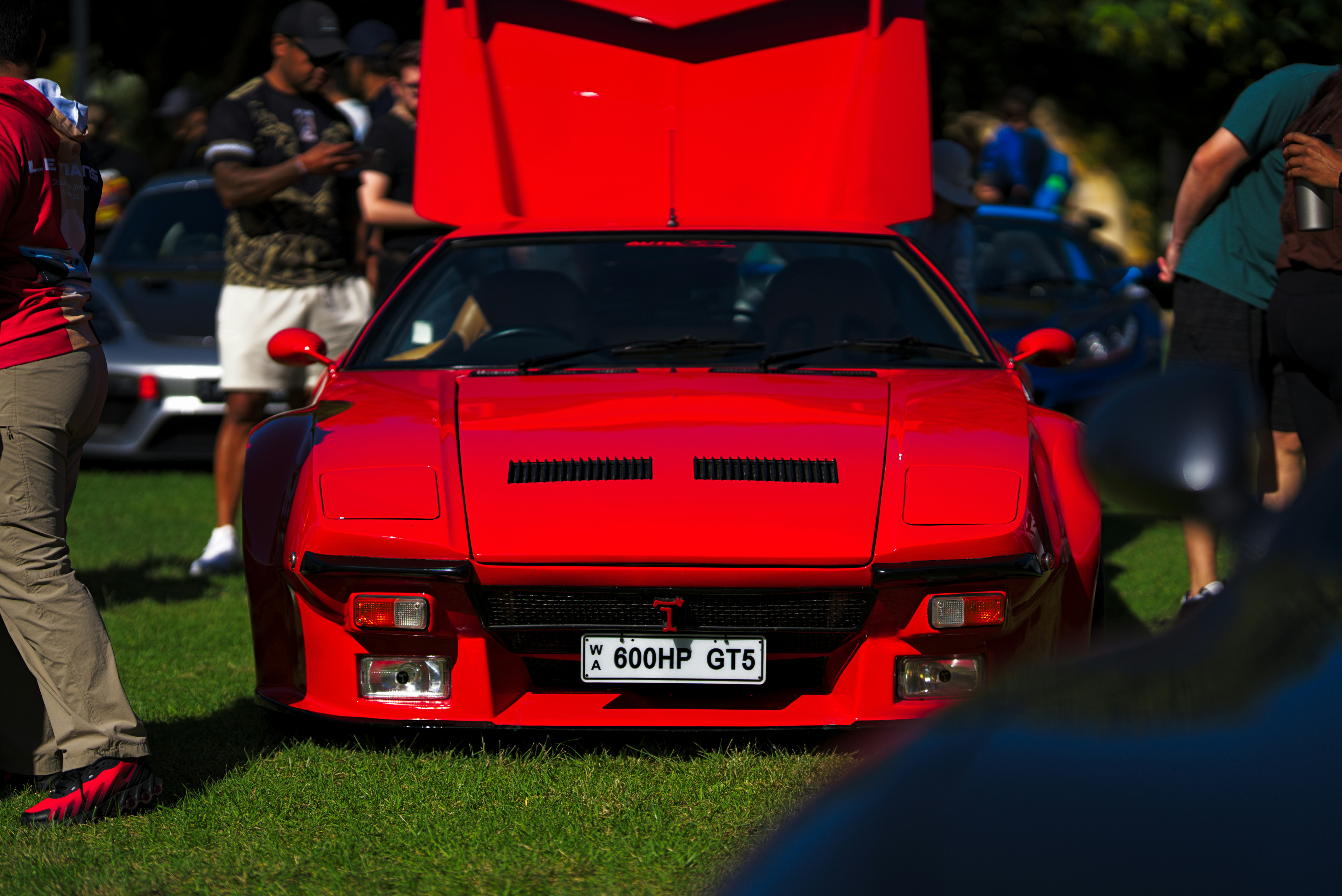 Red Dragon Gate: A Daring Car Show Moment with the Open Hood