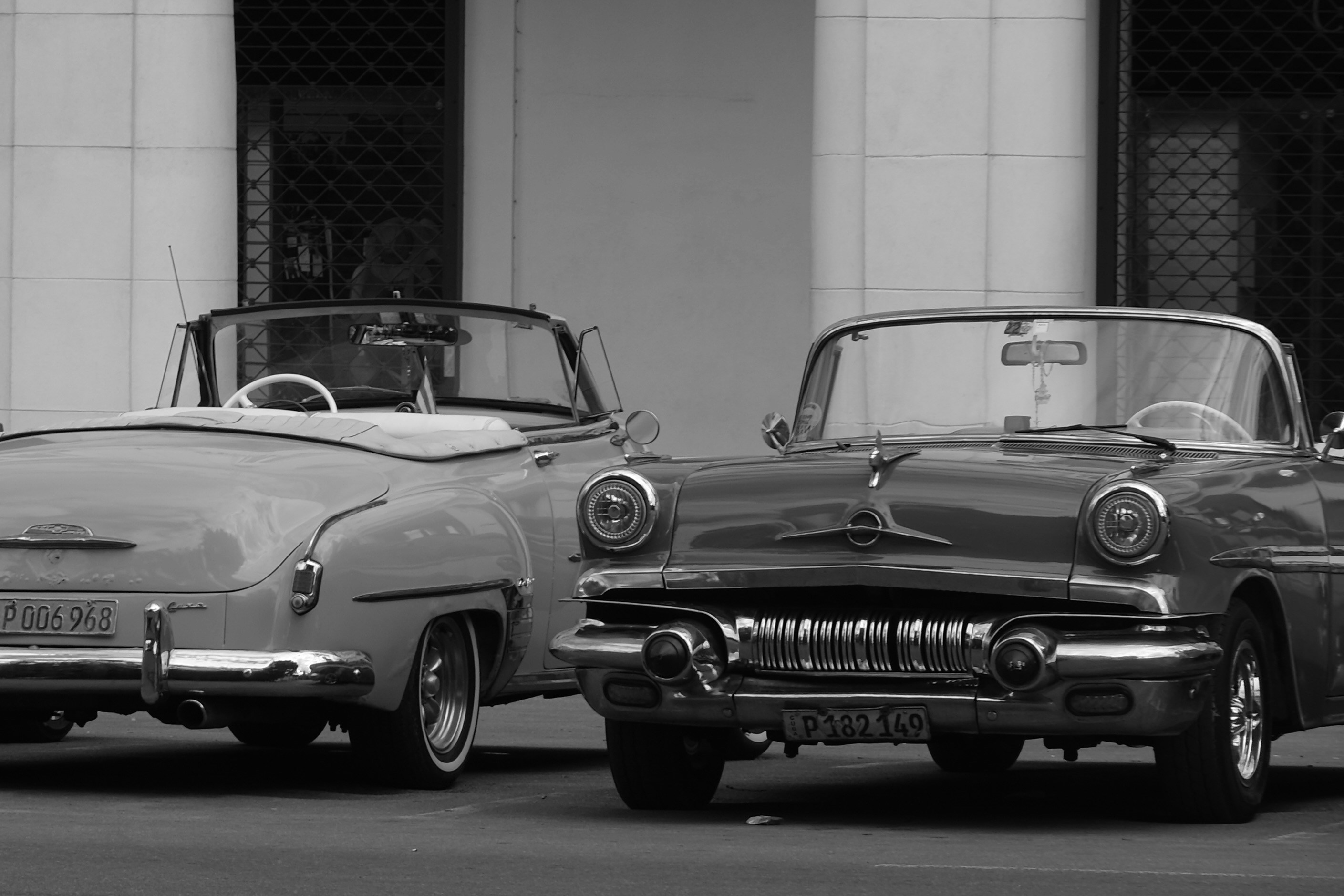 Chrome Reflections: Classic Convertibles Rest by the Courtyard