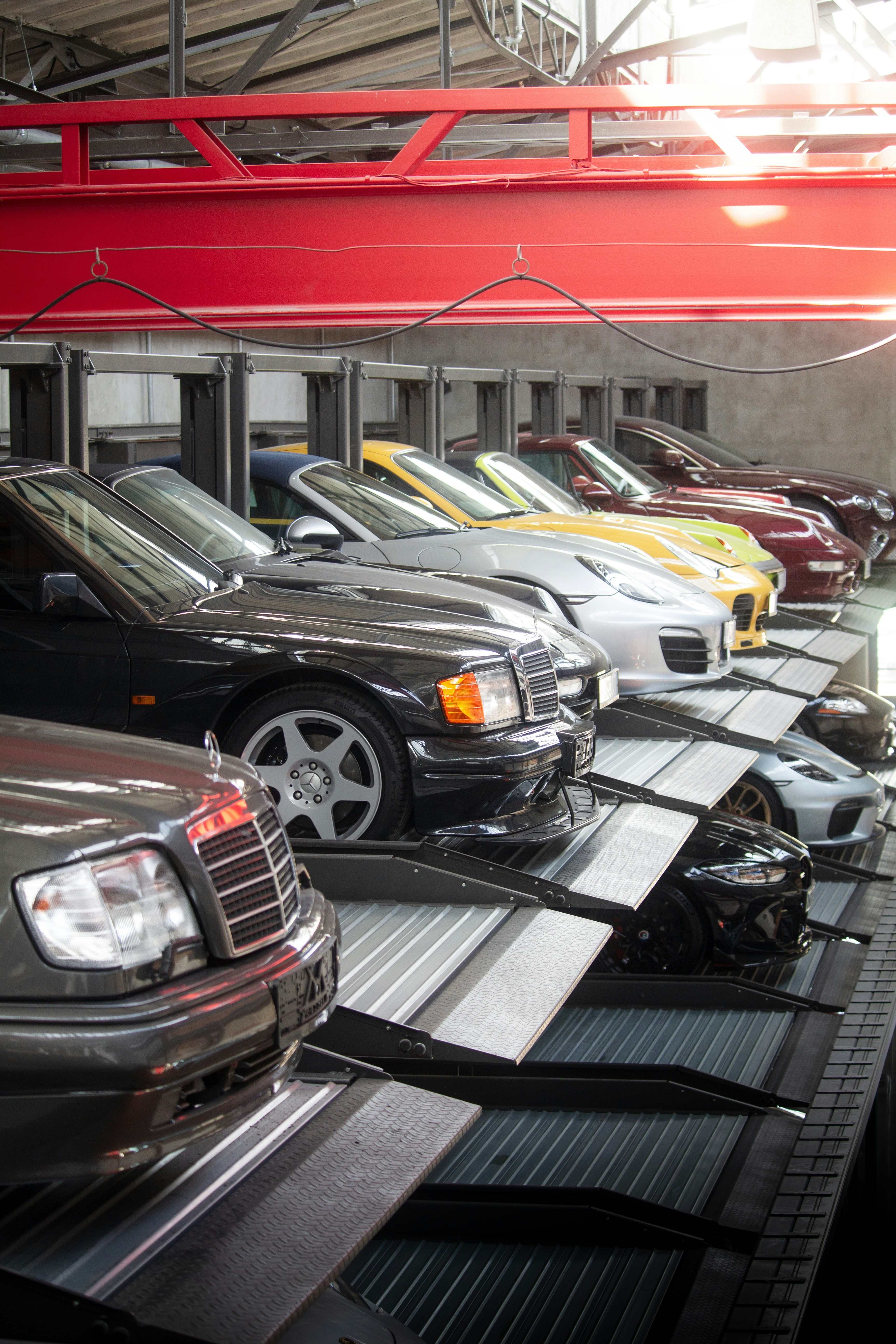 Lineup on the Lift: A Row of Sleek Classics in a Red-Washed Garage