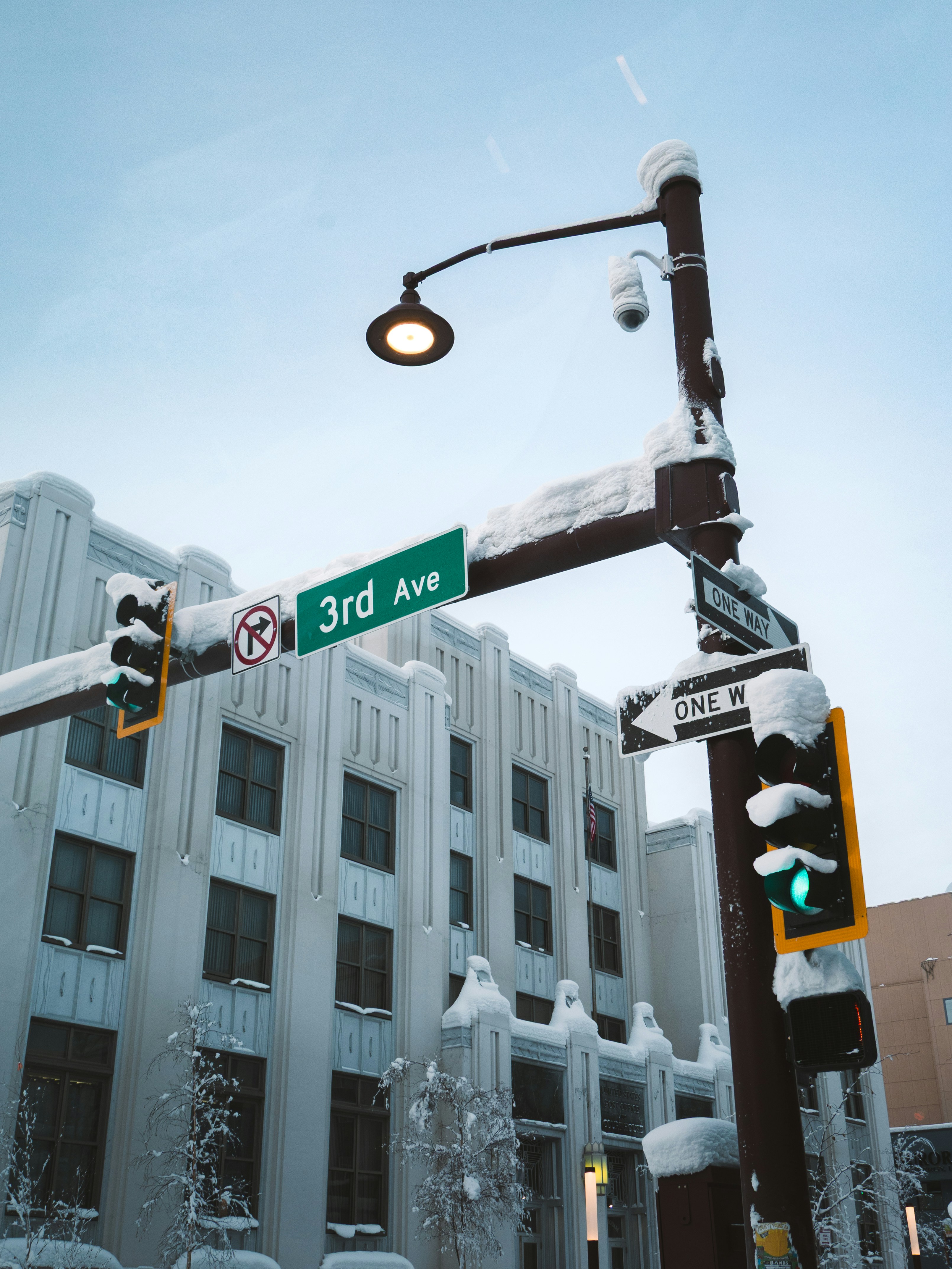 Snow-Laden Crossroads: 3rd Ave Sign Amid Frozen Streetlight