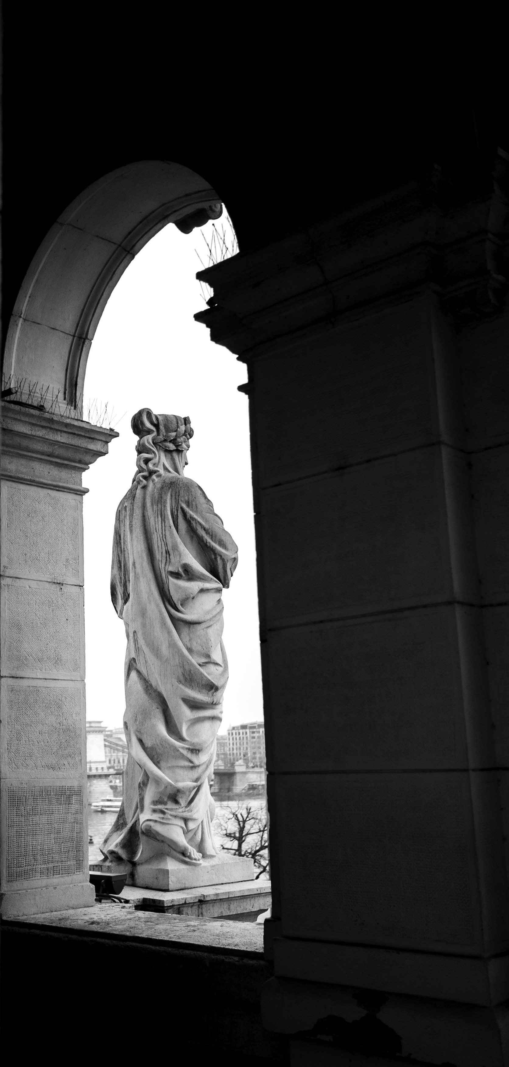 Statue Framed by Arch: Quiet Grace Between Light and Shadow