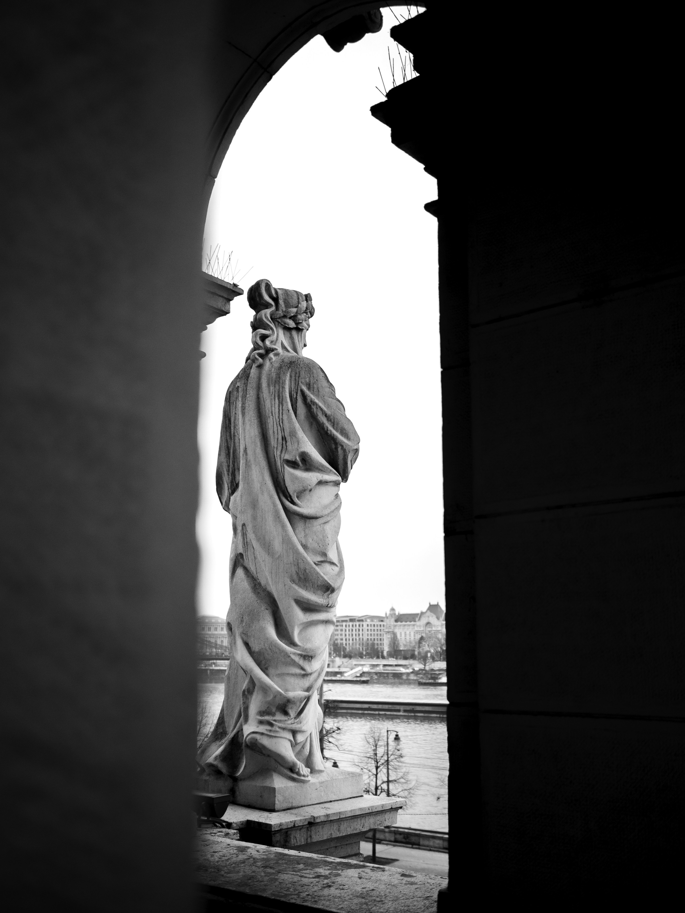 Statue Framed by Parabolic Arch: A Quiet Moment Over the River