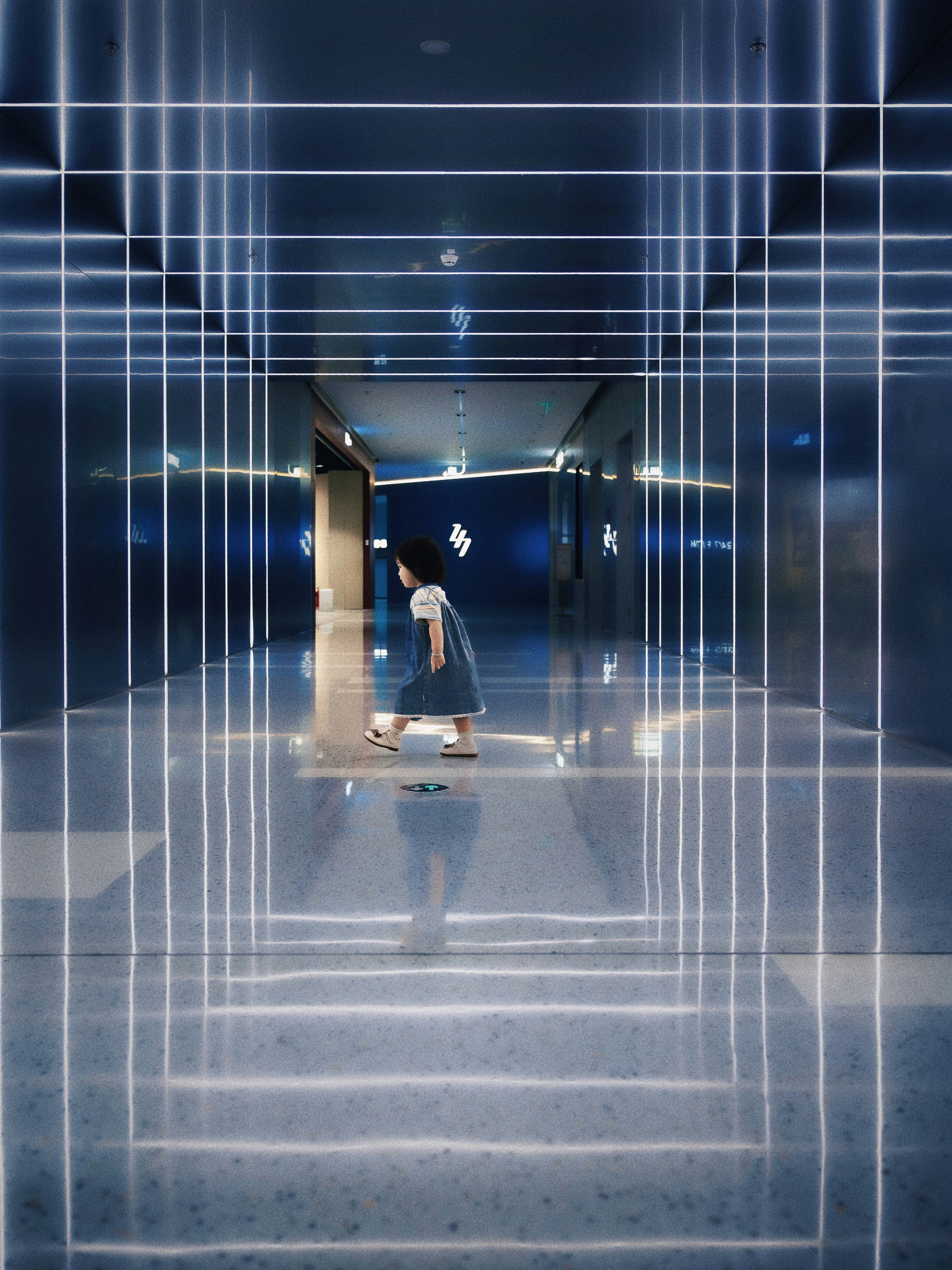 Neon Corridor: A Child's Quiet Walk Through a Glass-Lined Maze