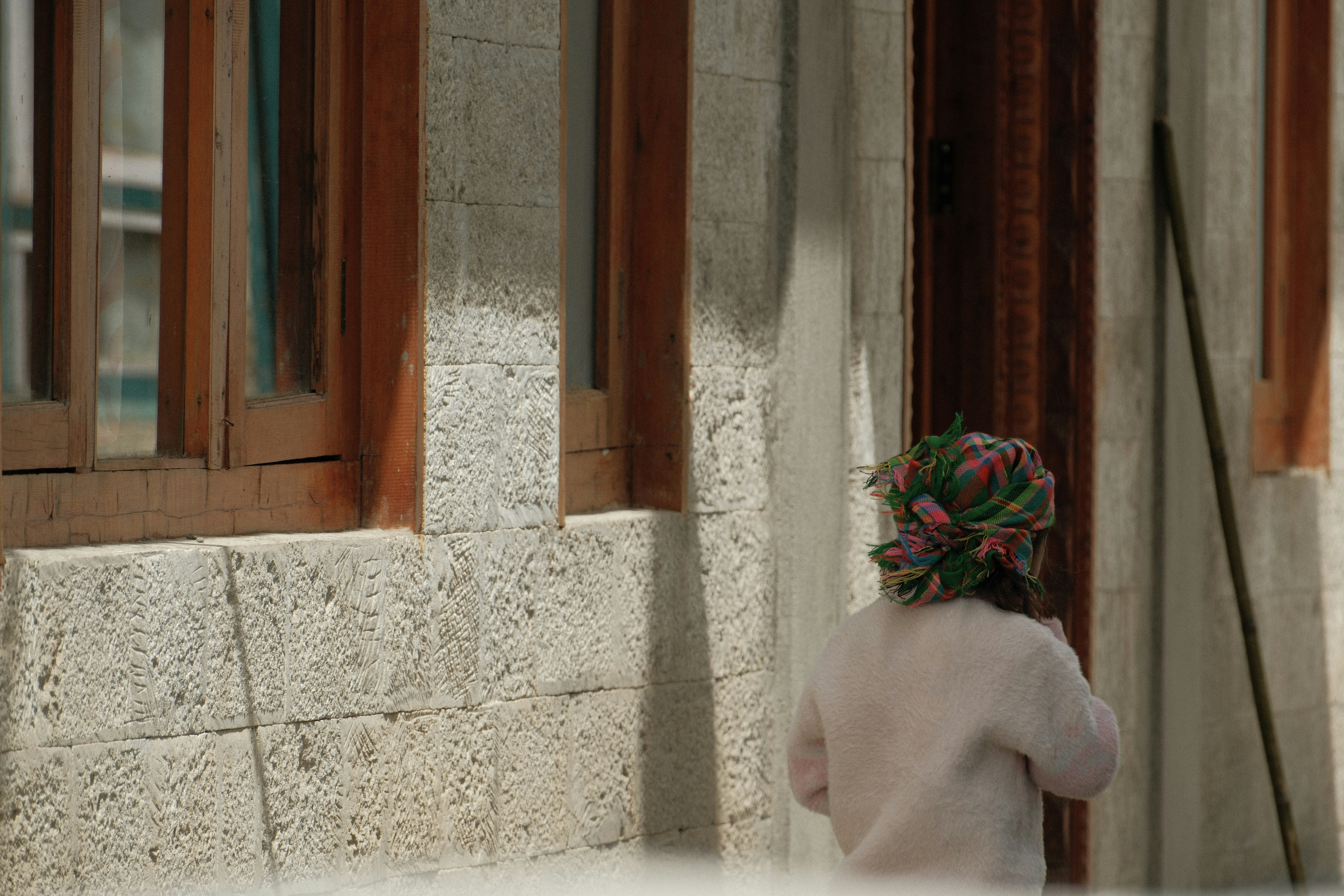 Dusty Wall, Warm Coat: A Child at the Threshold