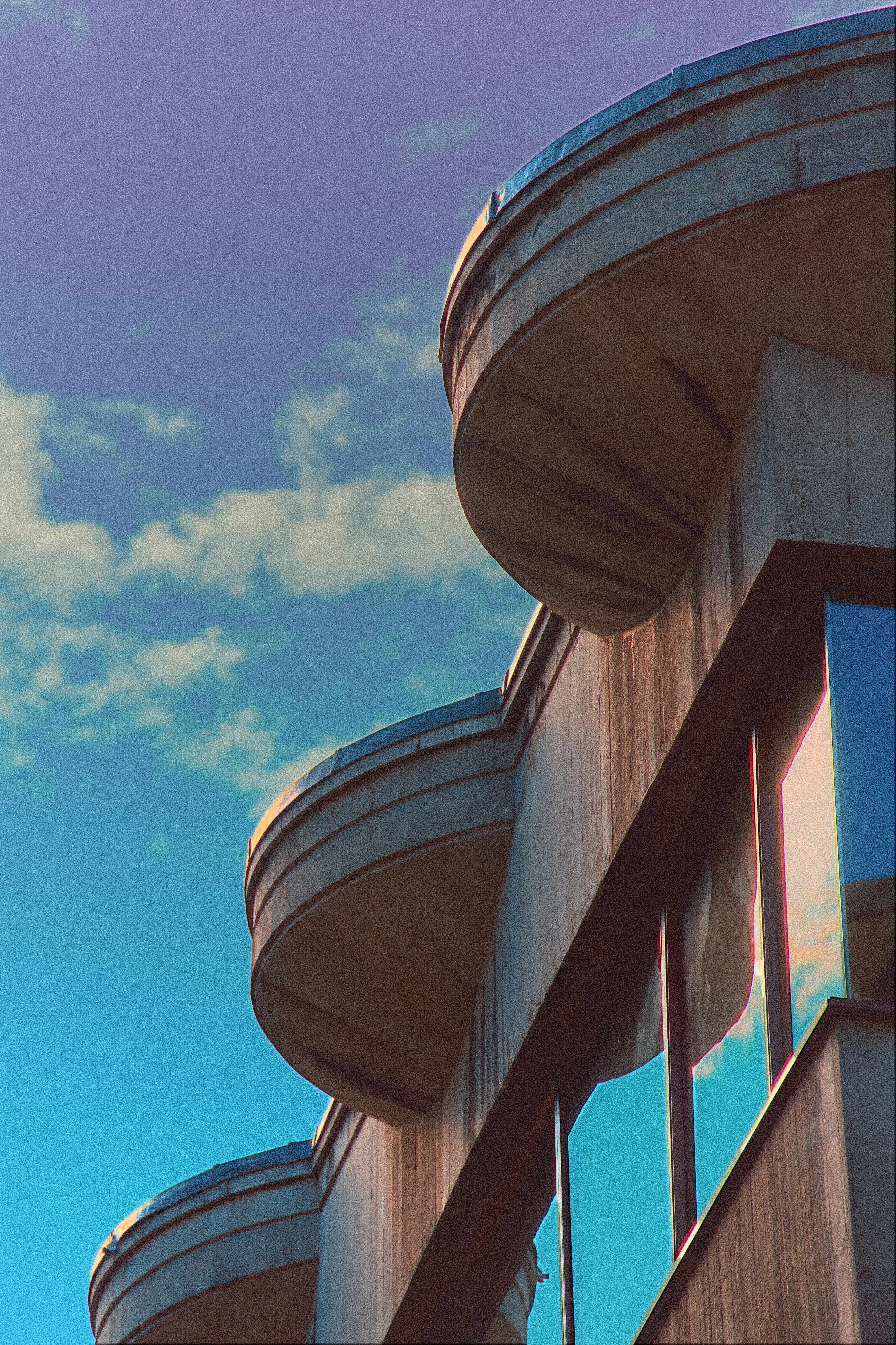 Curved Concrete Overhangs Catch a Sky-Willed City Light