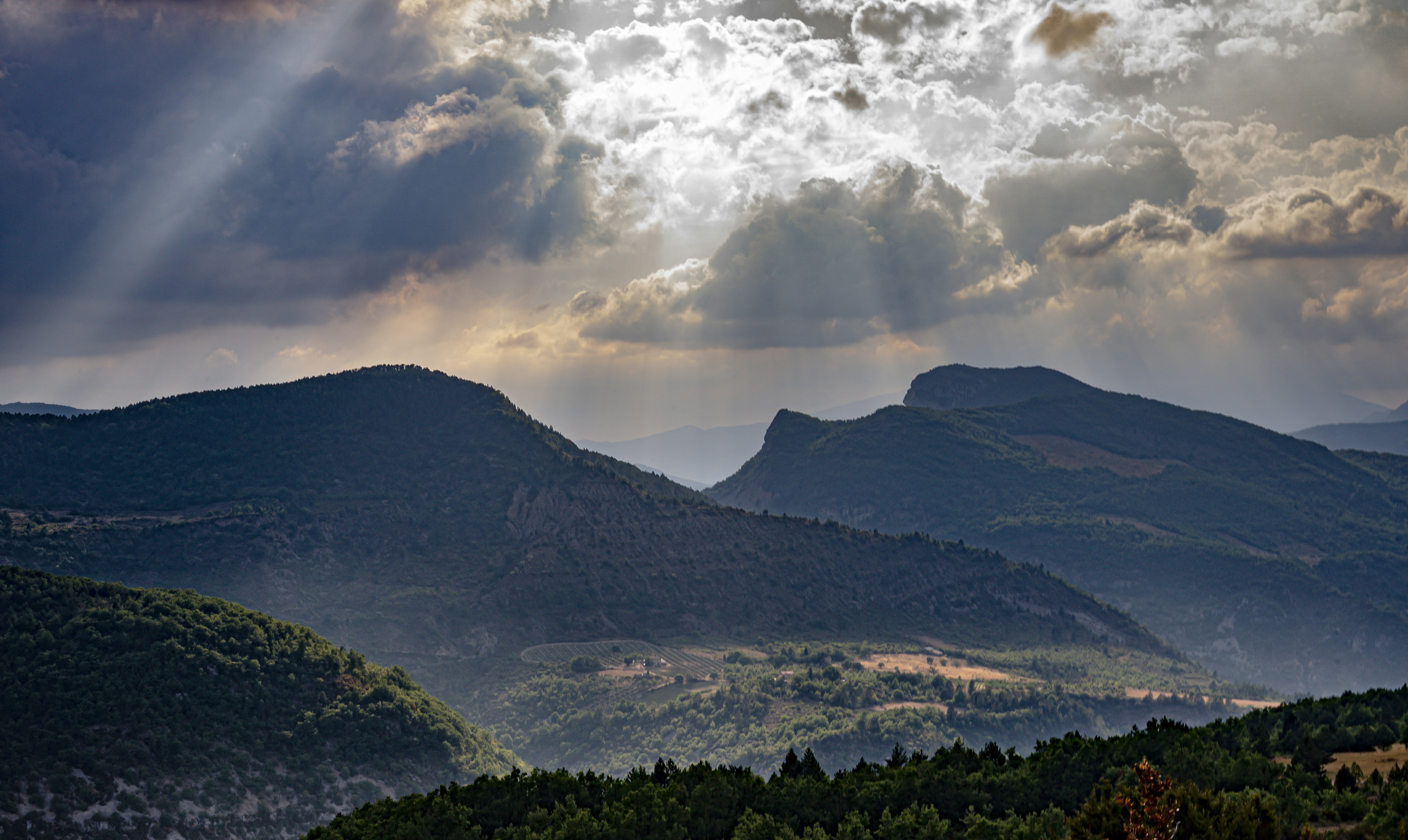Sunbeams over the Ridge: Quiet Mountains under Shifting Clouds