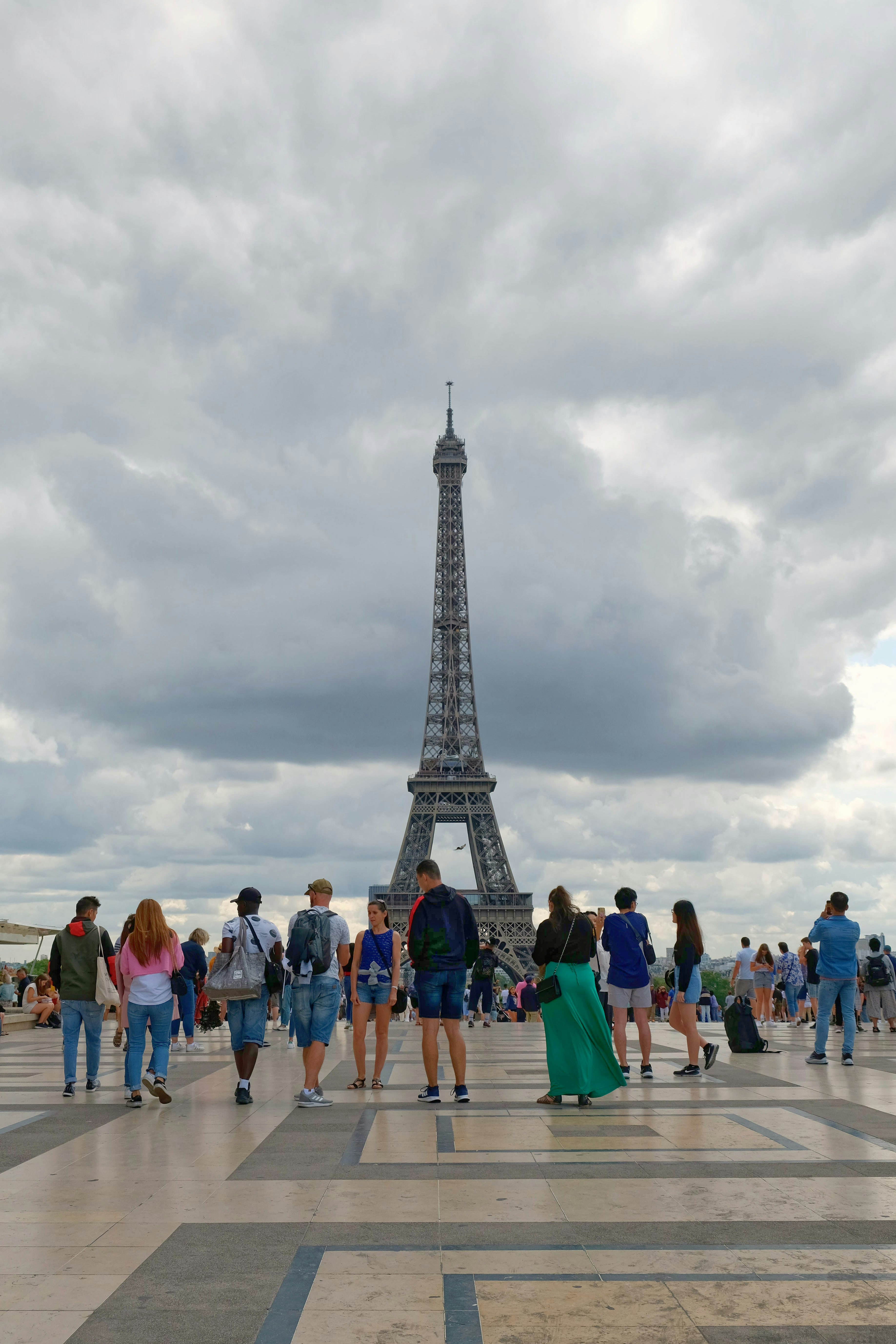 Tourists on the Plinth: A Courtyard Portrait of the Eiffel Tower