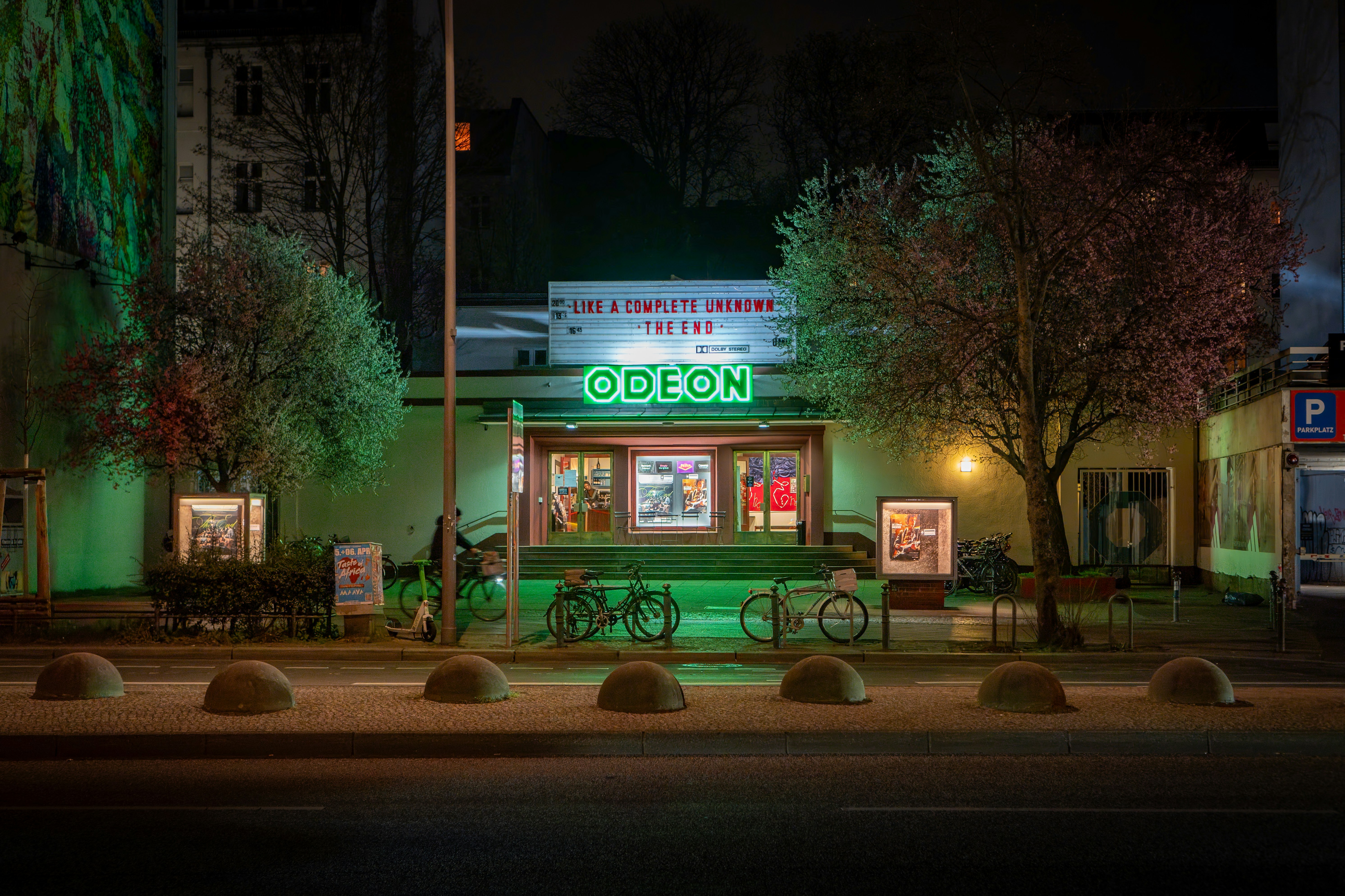 Neon Odeon at Night: Green Signage and Quiet Street