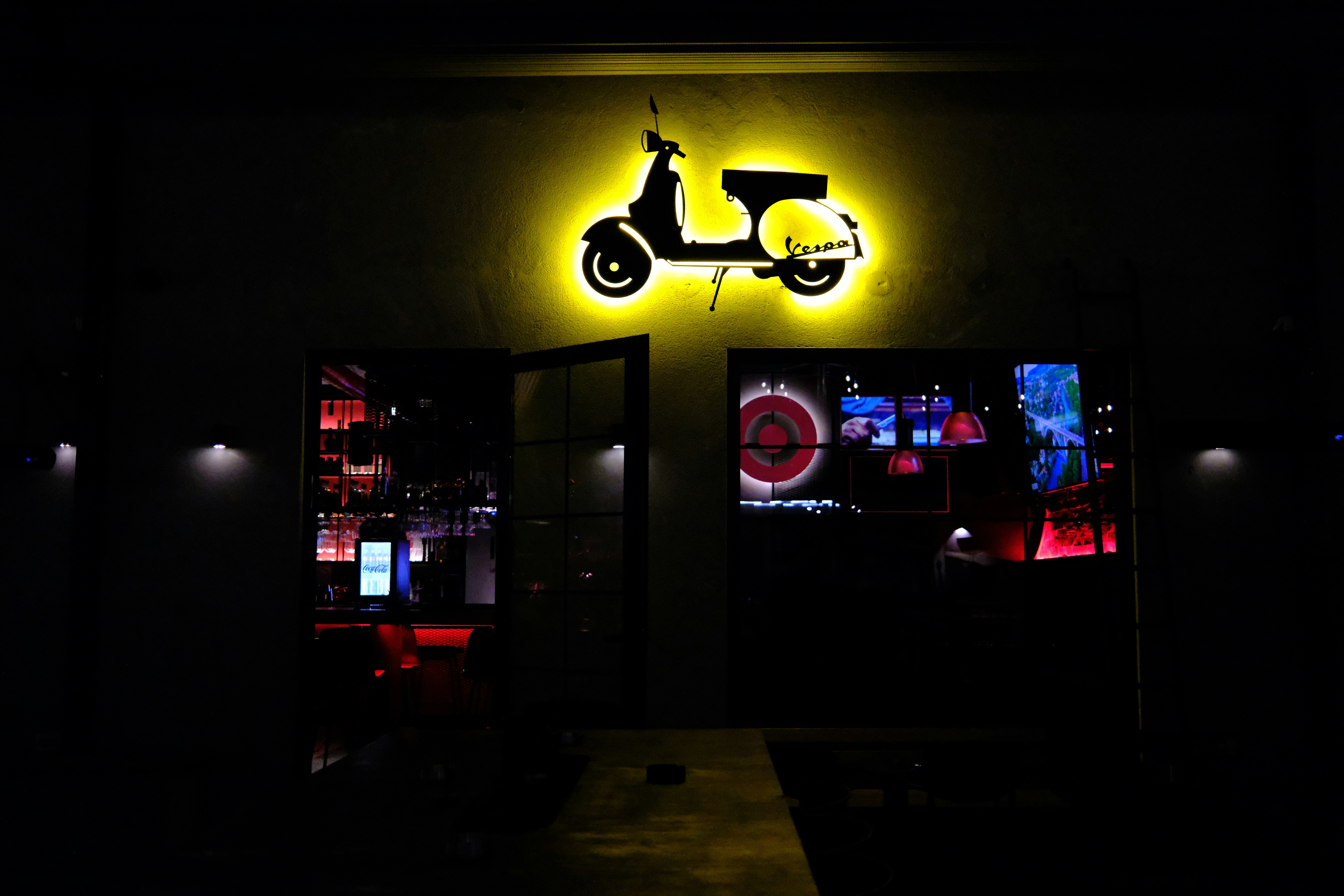 Luminous Scooter Signover: Neon Spotlight on a Night Entrance