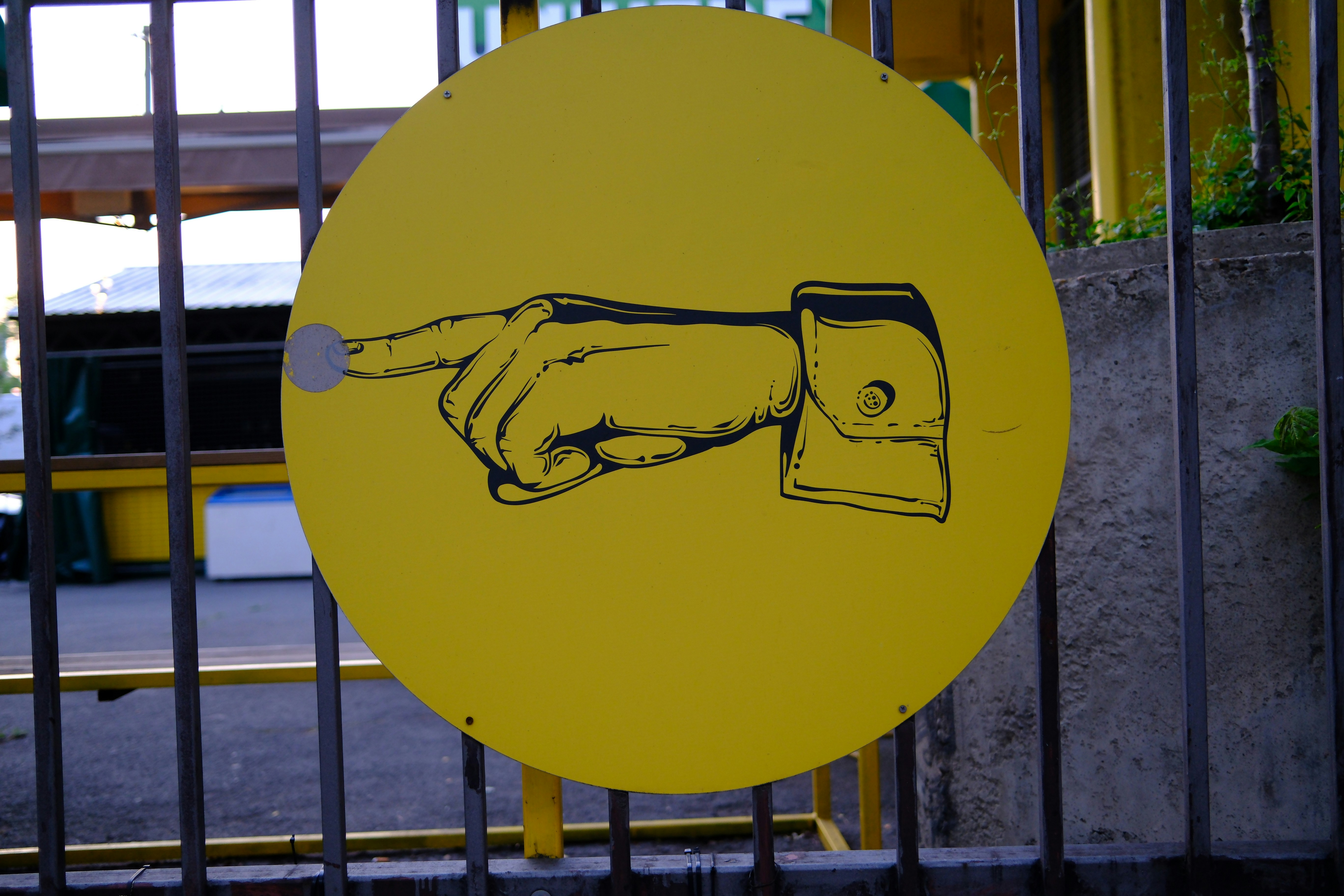 Yellow warning circle: pointing hand sign at playground