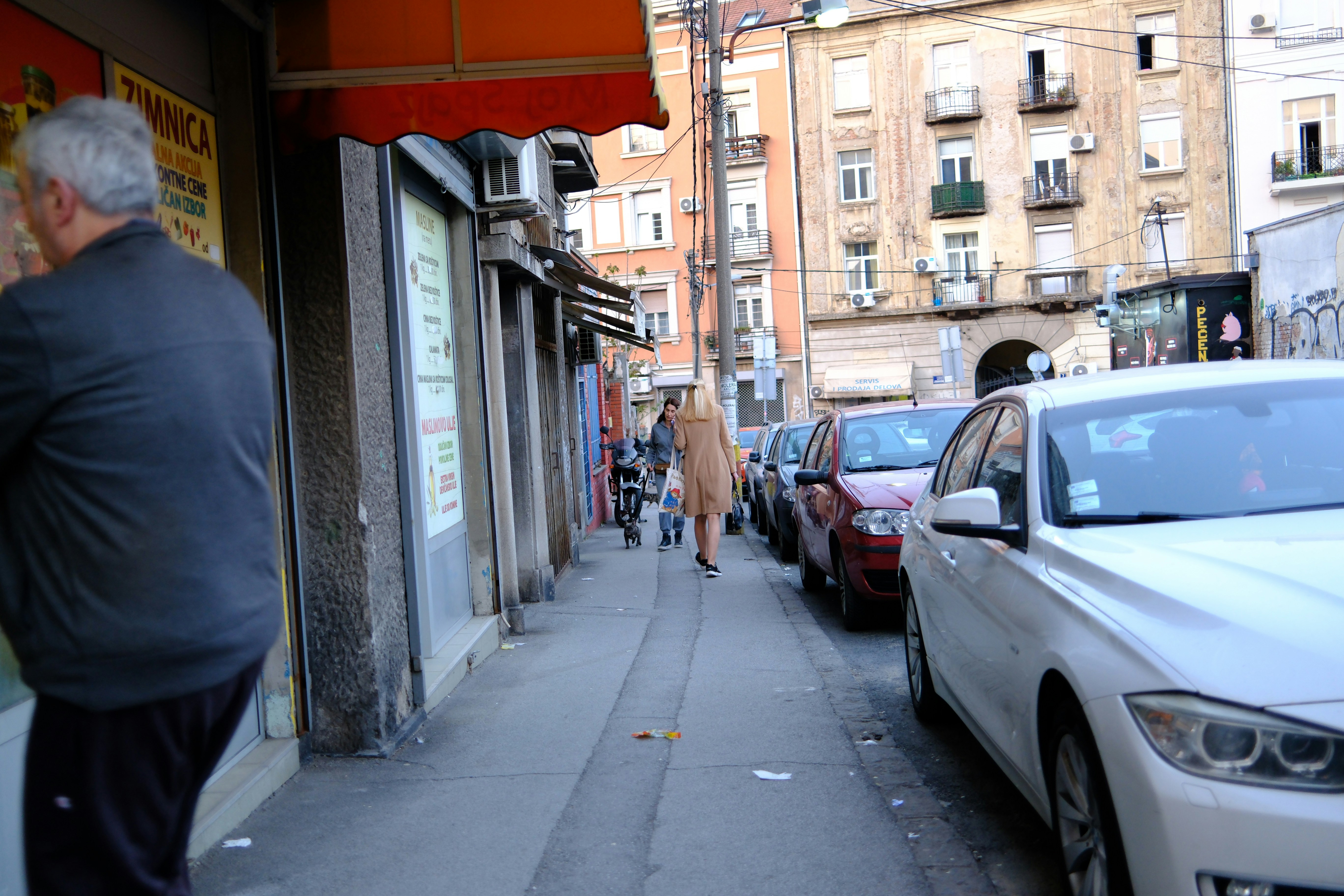 Streetline Silhouette: A Pedestrian, Cars, and Warm Facades in Evening Light