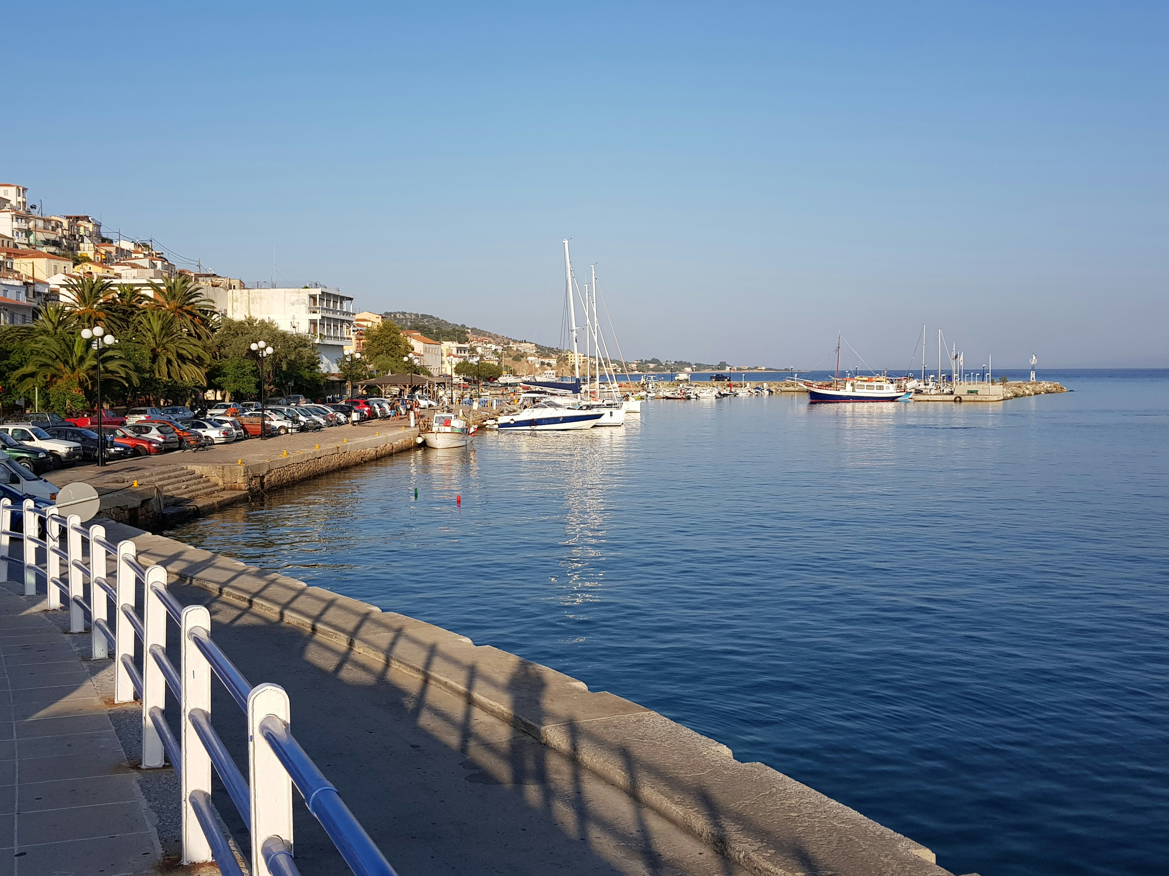 Sunlit harbor promenade with moored boats