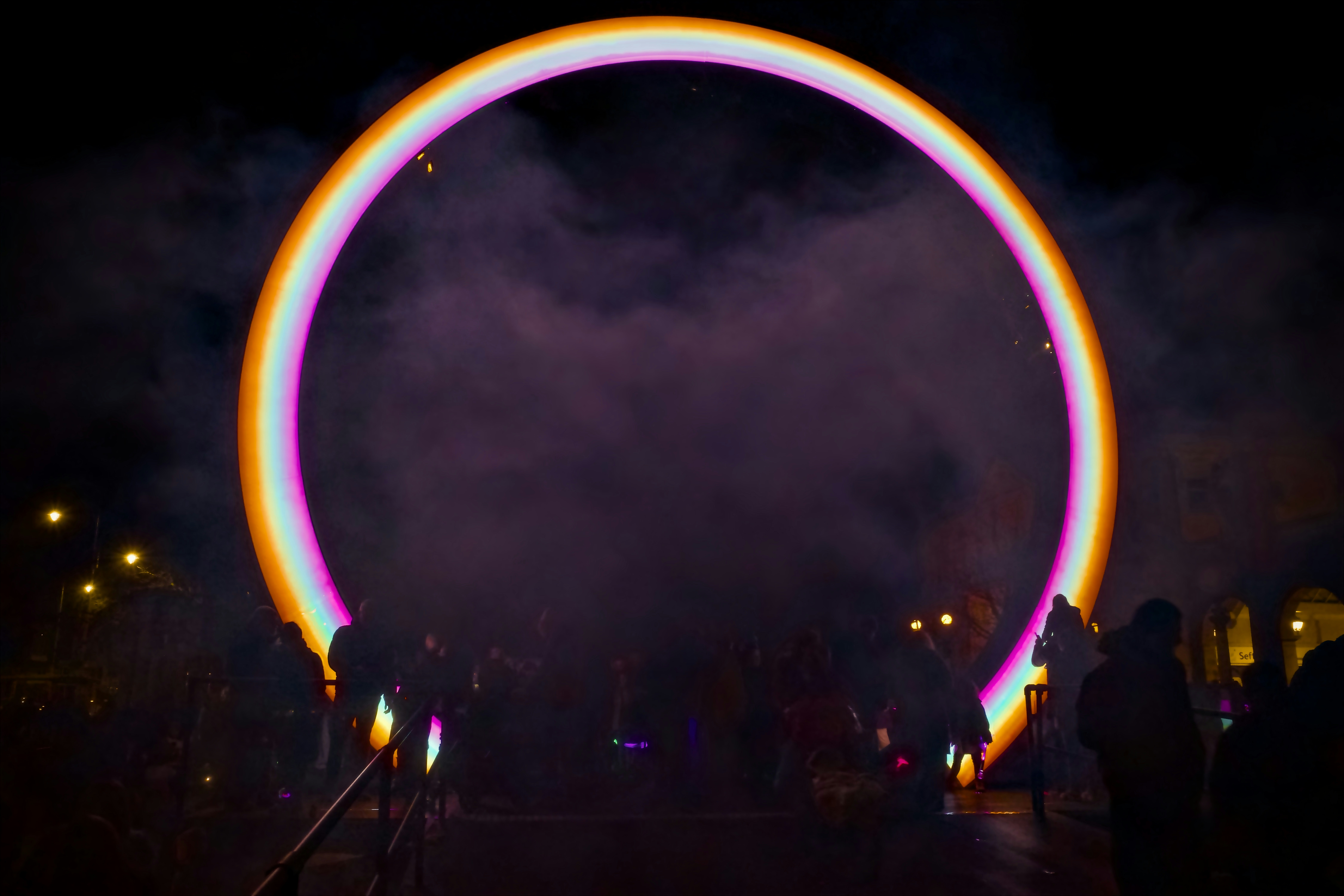 Neon Circle: A Nighttime Ring of Light with Spectators