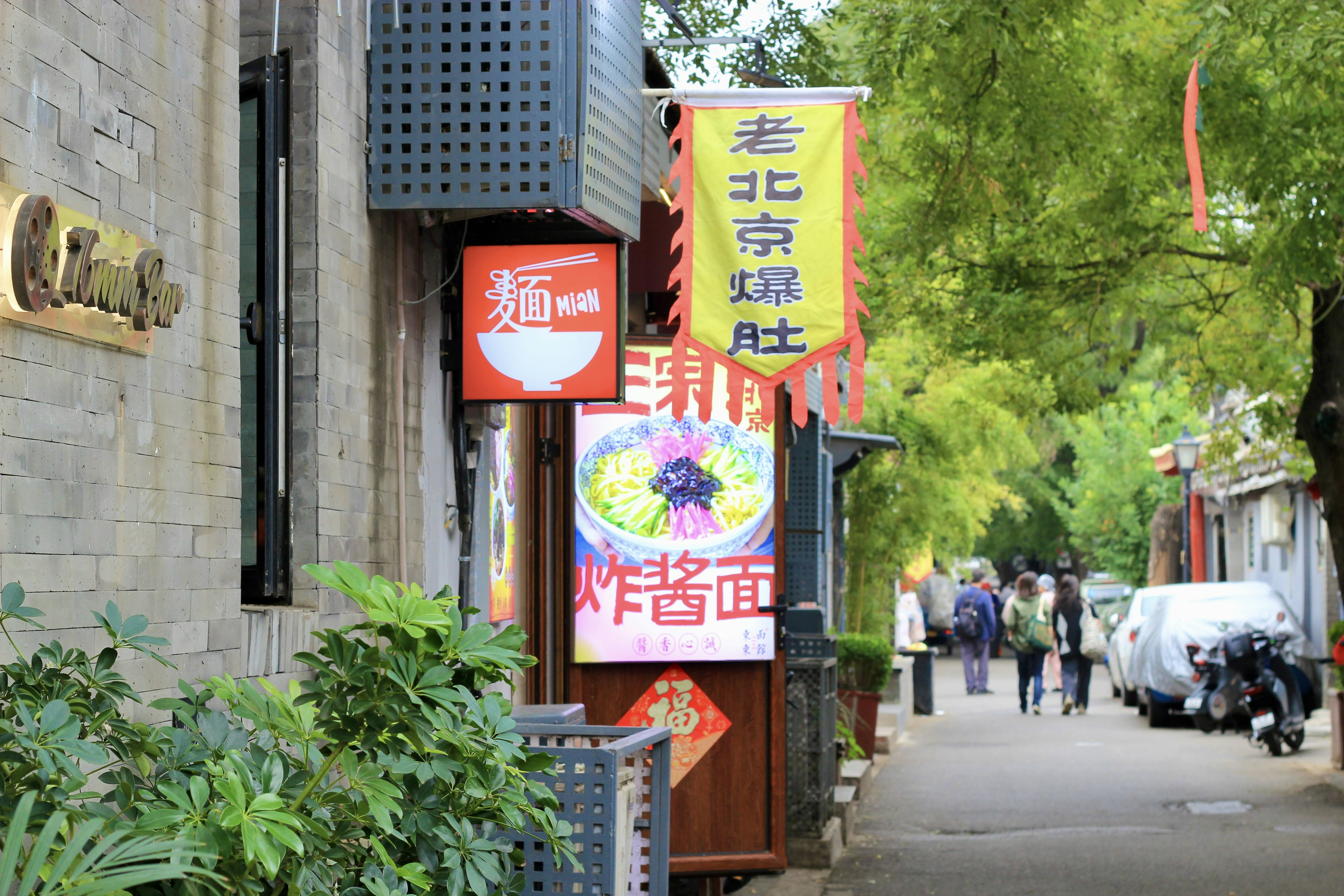 Street-side Signage and Café Façade Framed by Greenery