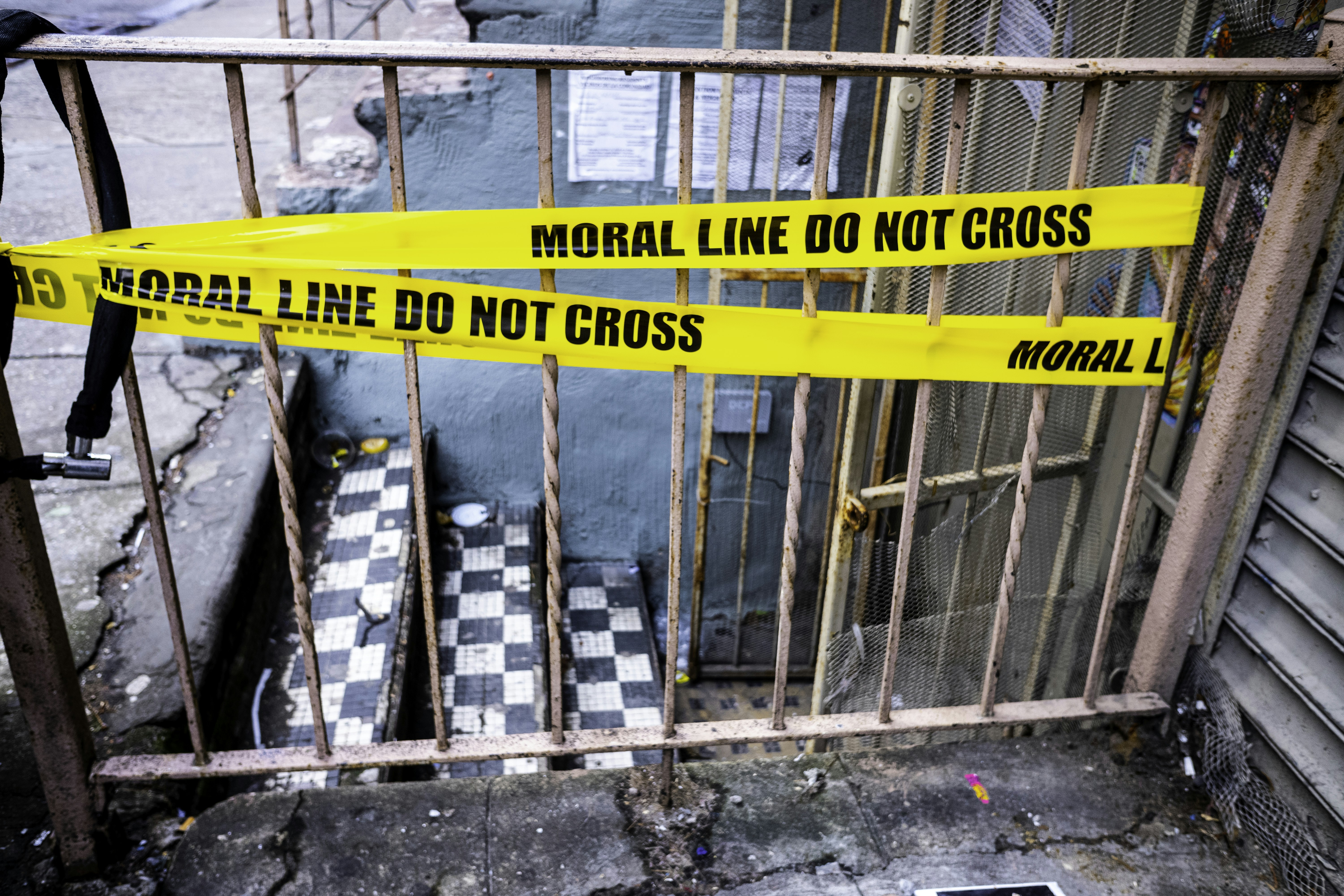 Yellow Tape Echoes Through a Rusted Balcony Gap