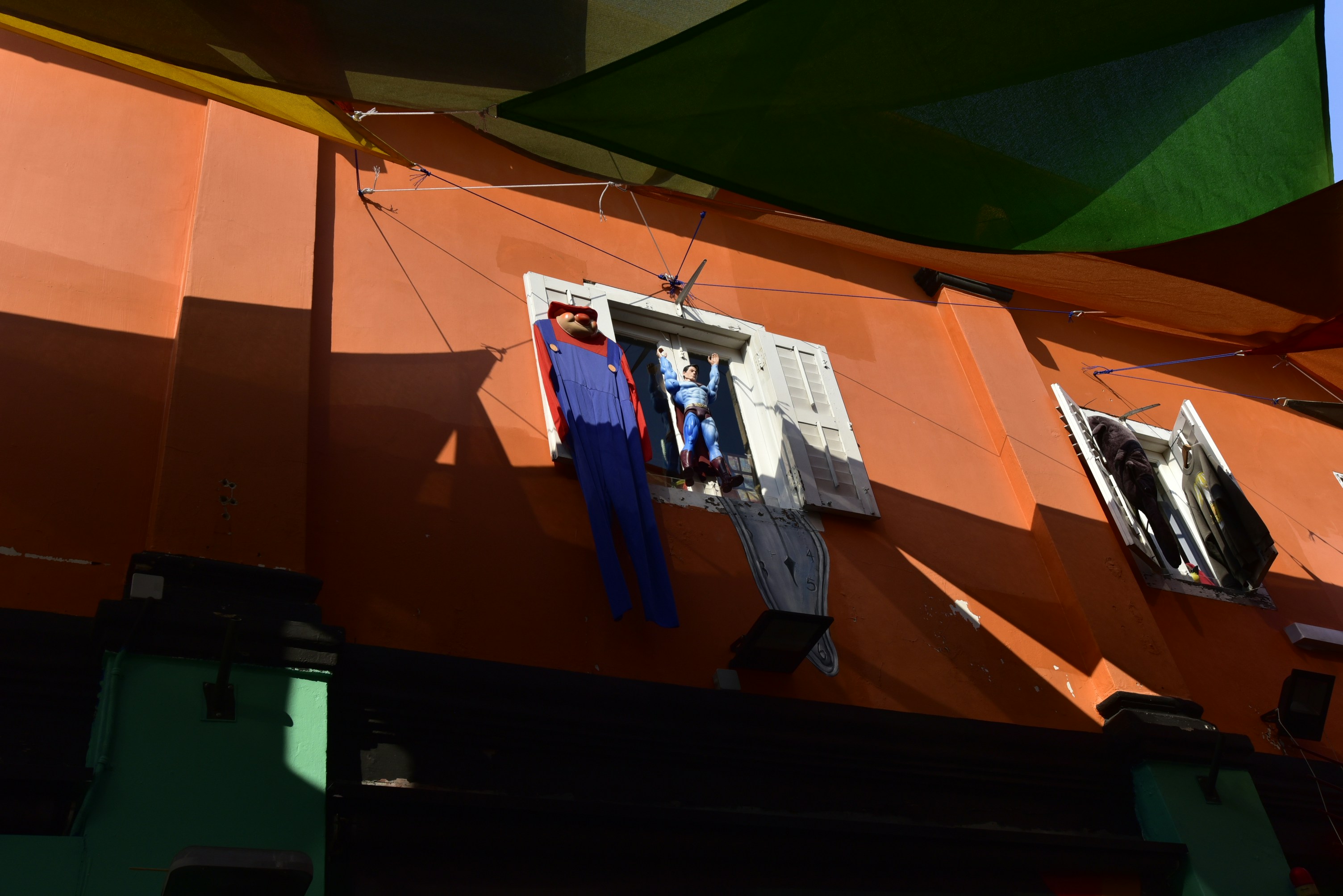 Across the Orange Facade: Laundry Lines and Angular Sunlight