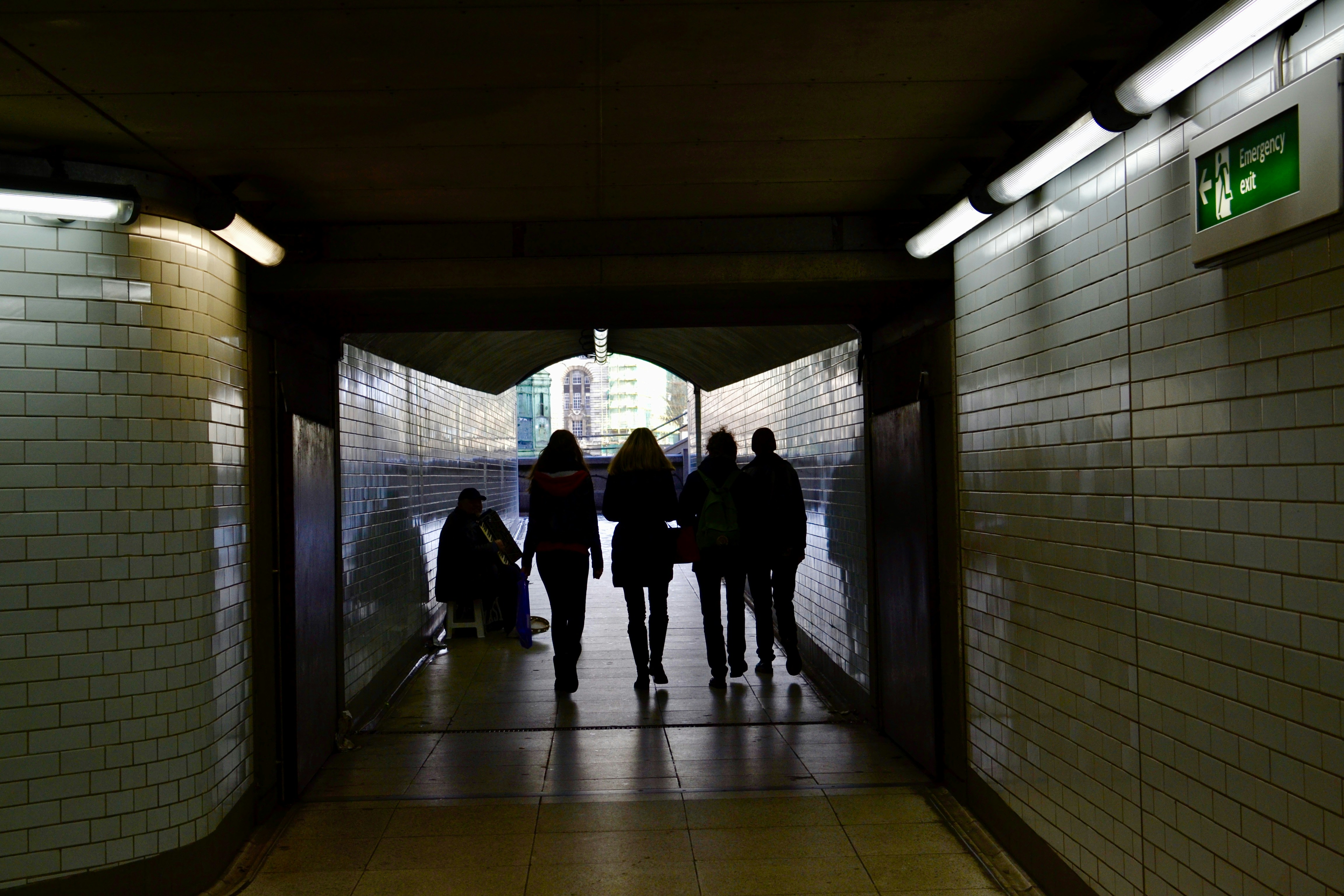 Silhouetted Travelers Exit the Subway Tunnel into Light