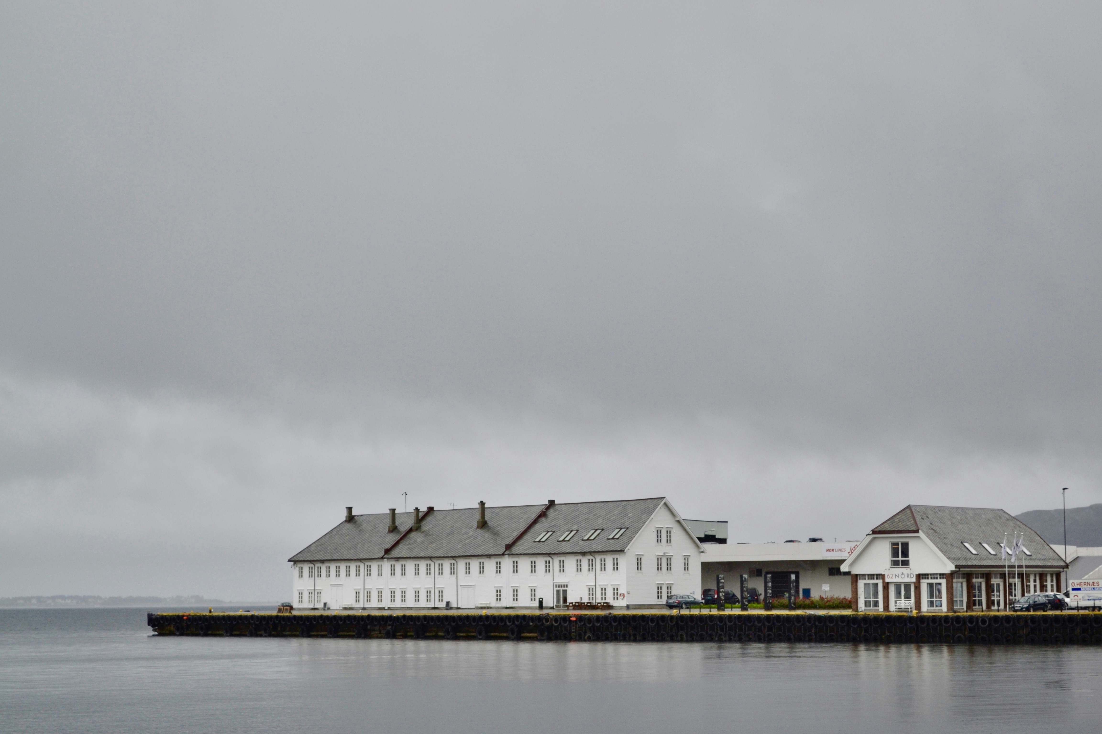 Harbor Row: White Warehouse and Pier Under moody Sky