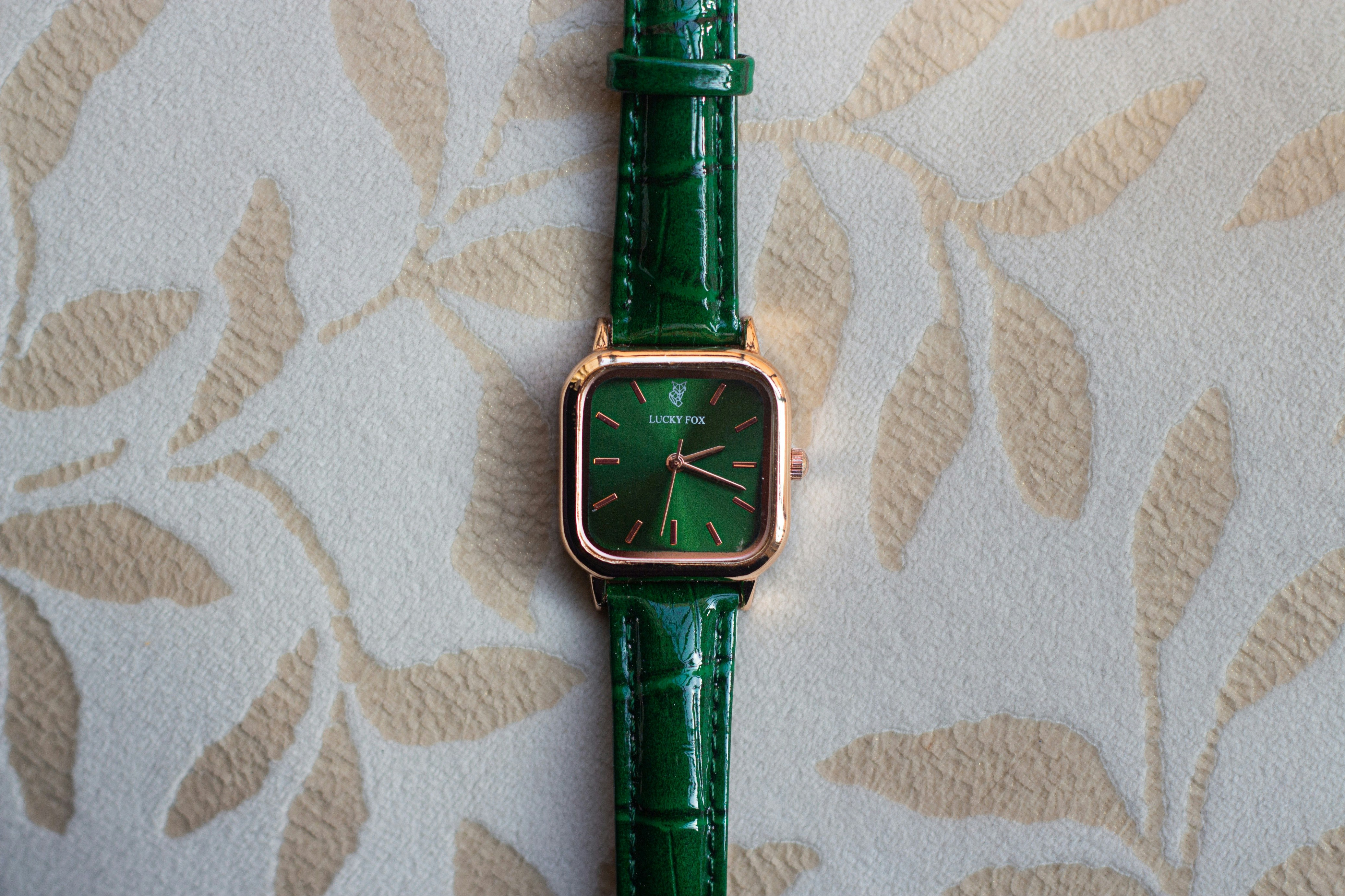 Emerald Timepiece: A Green Square on a Patterned Canvas