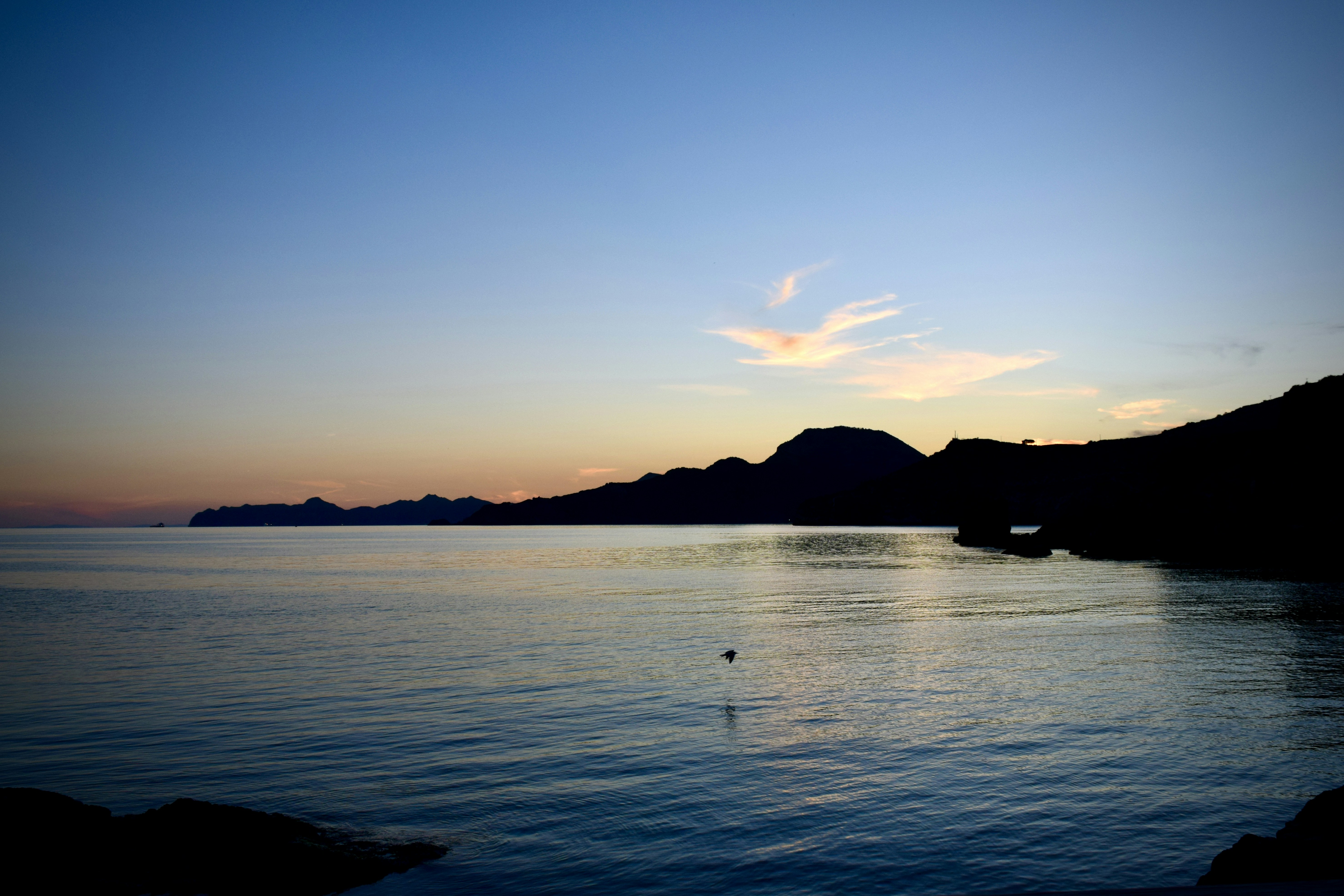 Horizon at Blue Hour: Calm Sea Under a Silhouette Ridge
