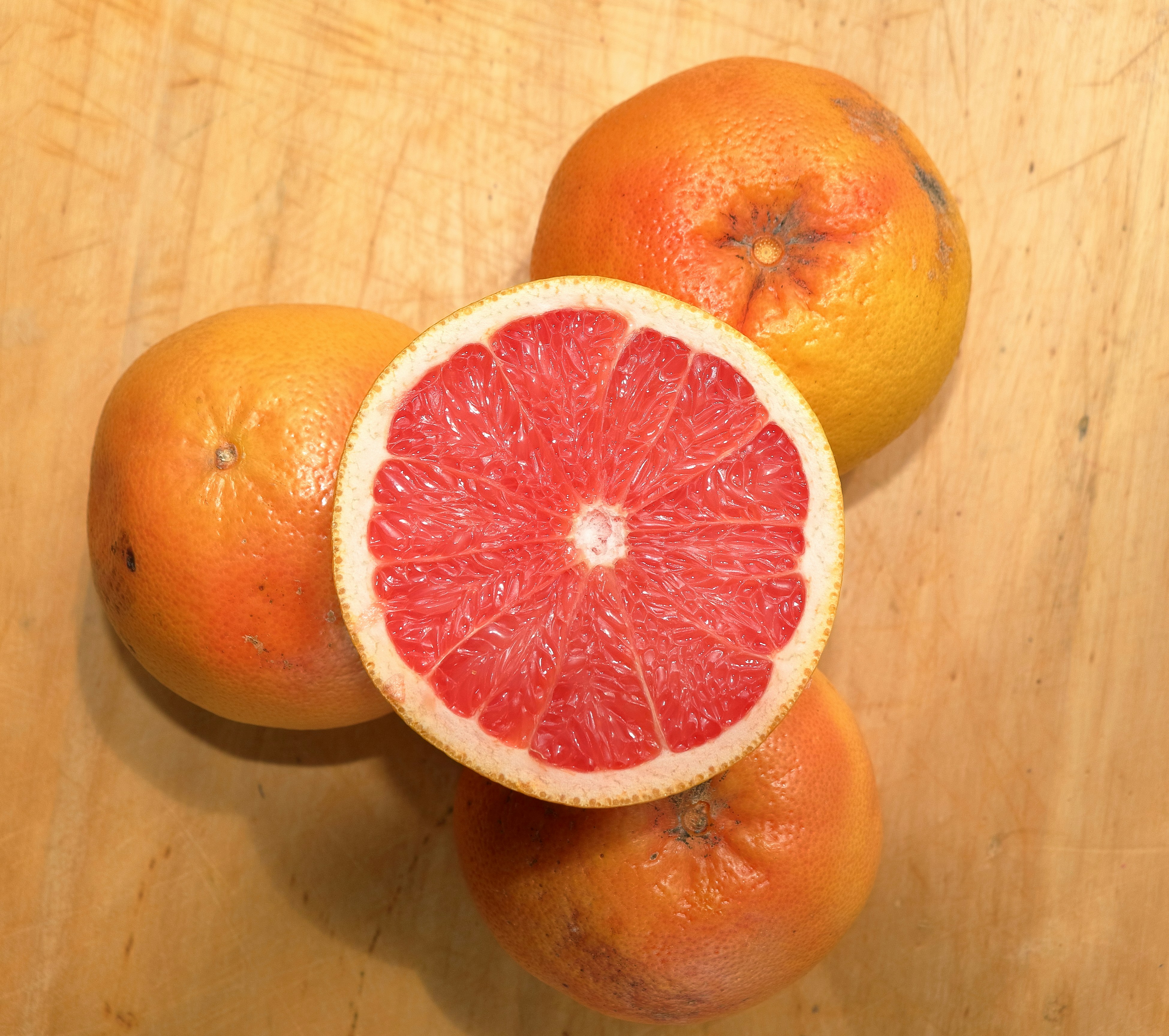 Citrus Quartet: A Half-Sliced Ruby Centered on a Wooden Stage