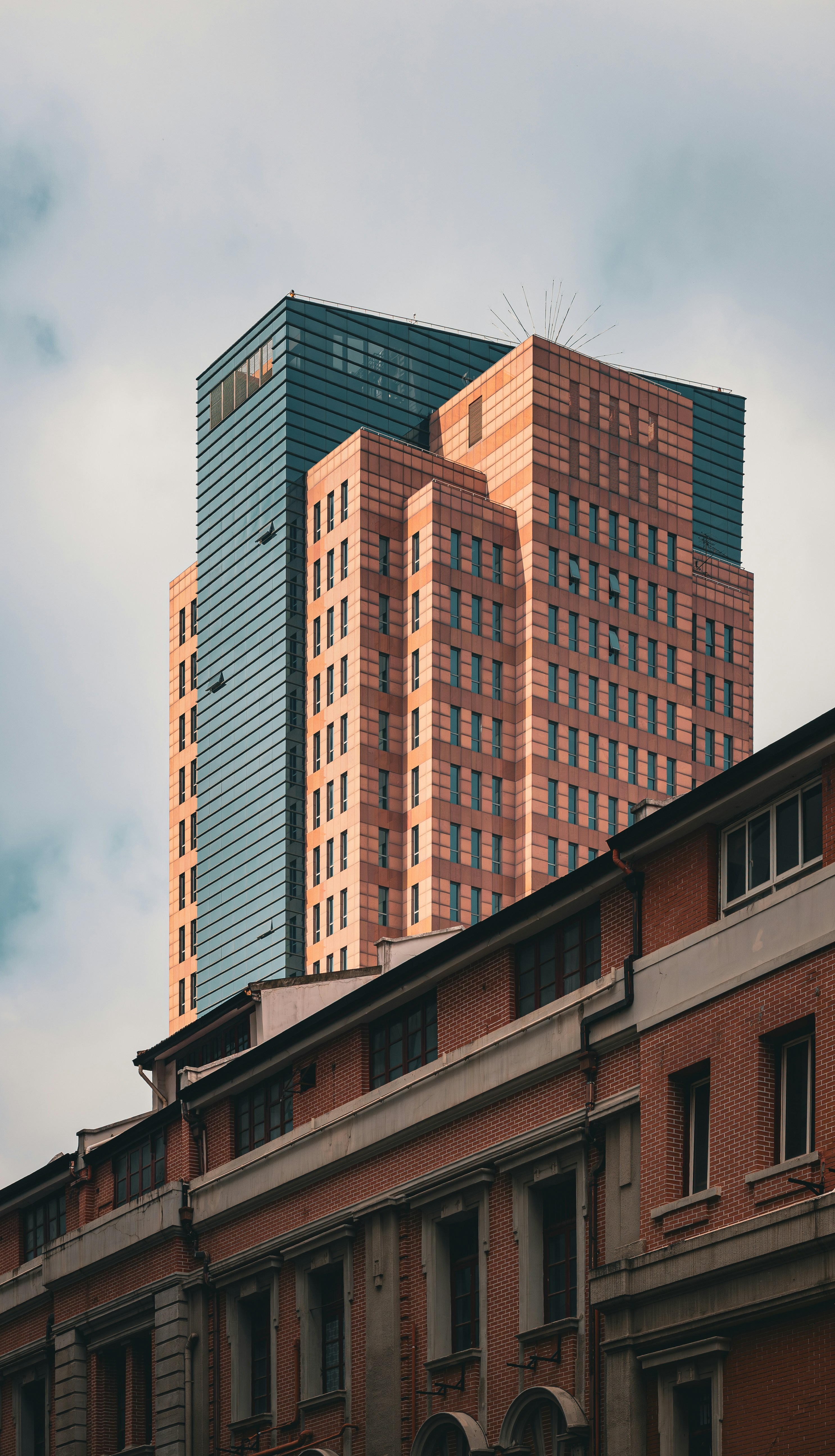 Towering Contrast: Brick meets Glass Against a Clear Sky
