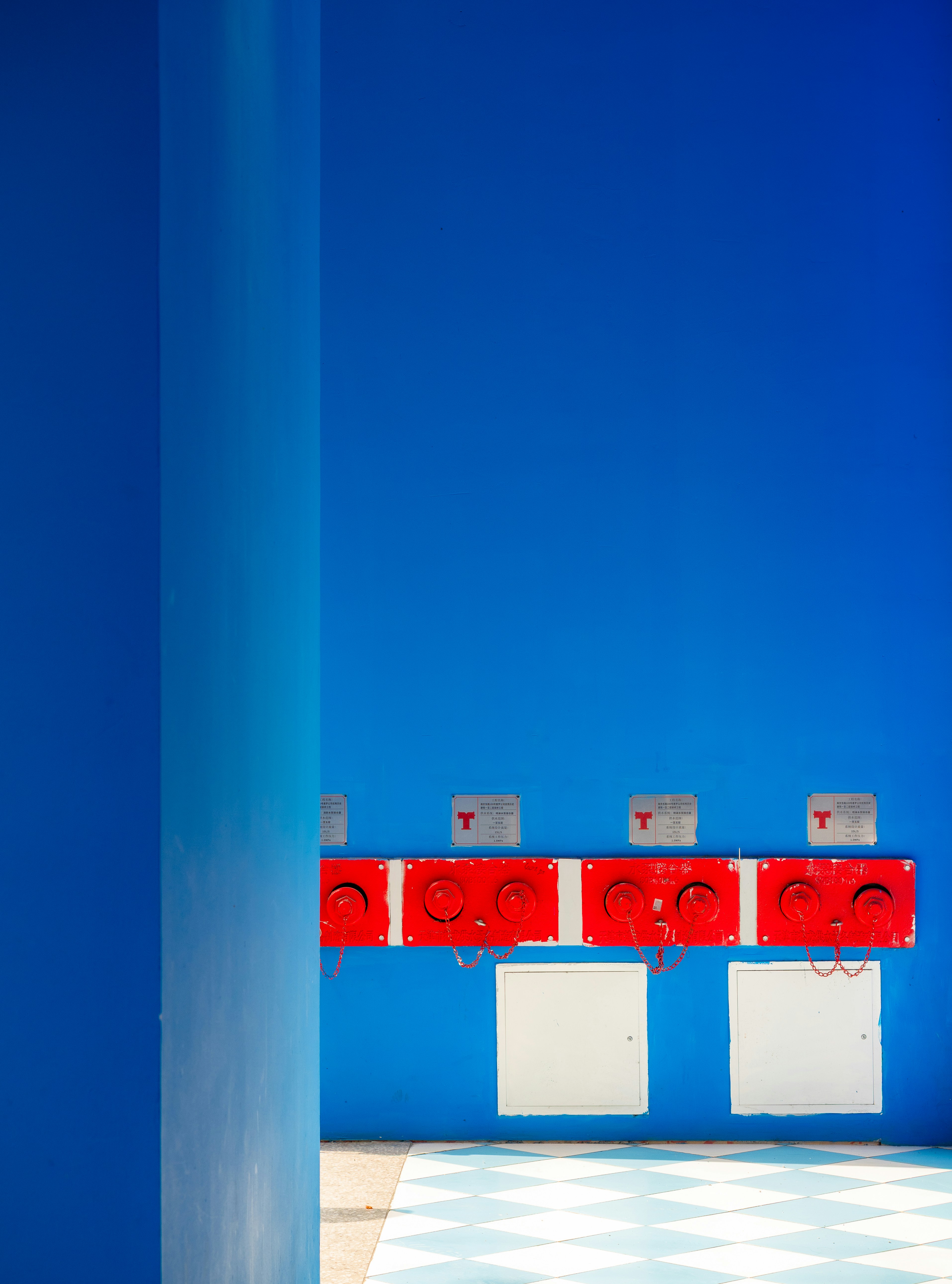 Blue Columnarga: Red Fire Hoses Against a Cerulean Wall