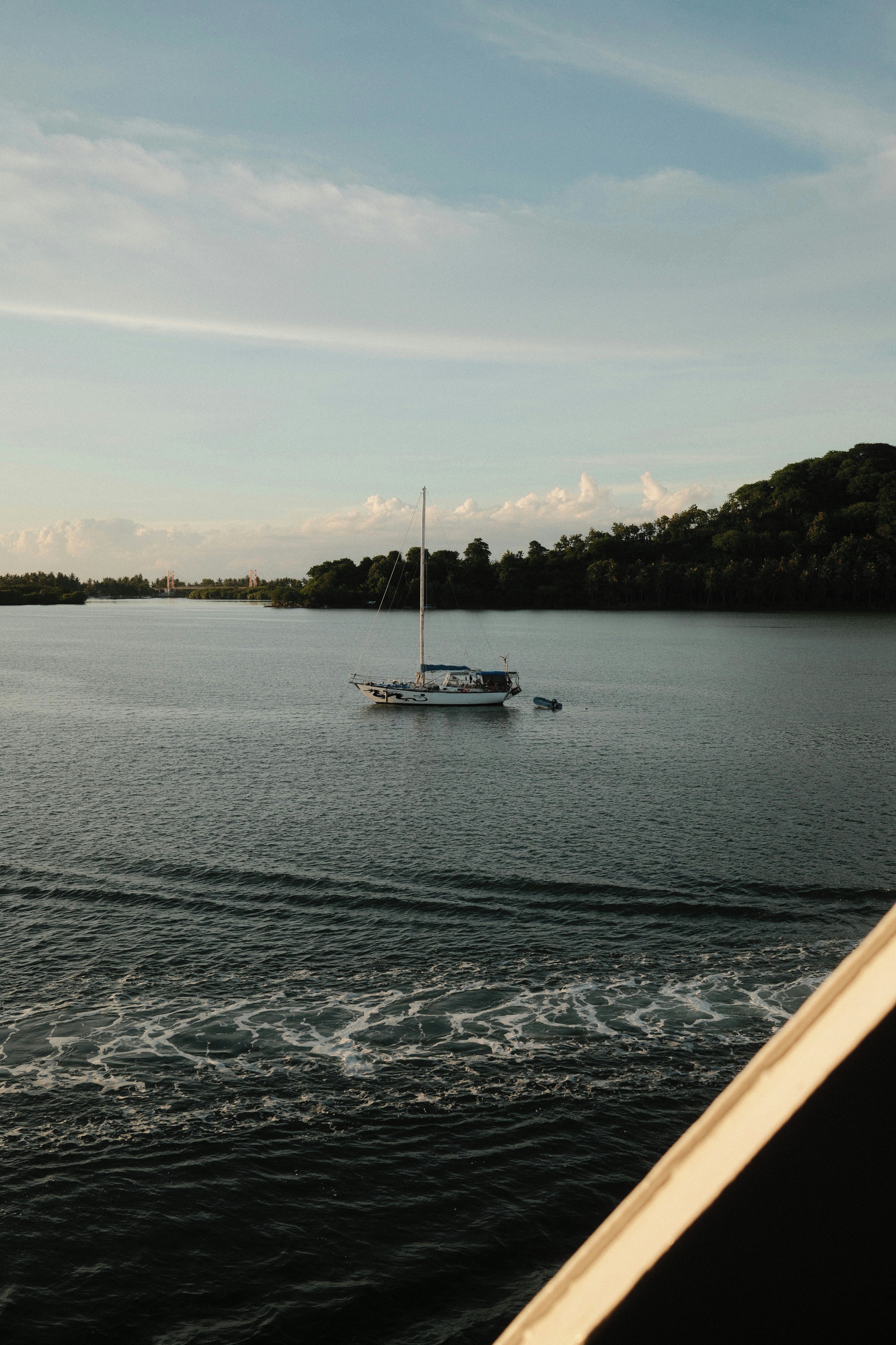 Sailboat Drifting Through Quiet Water at Dusk