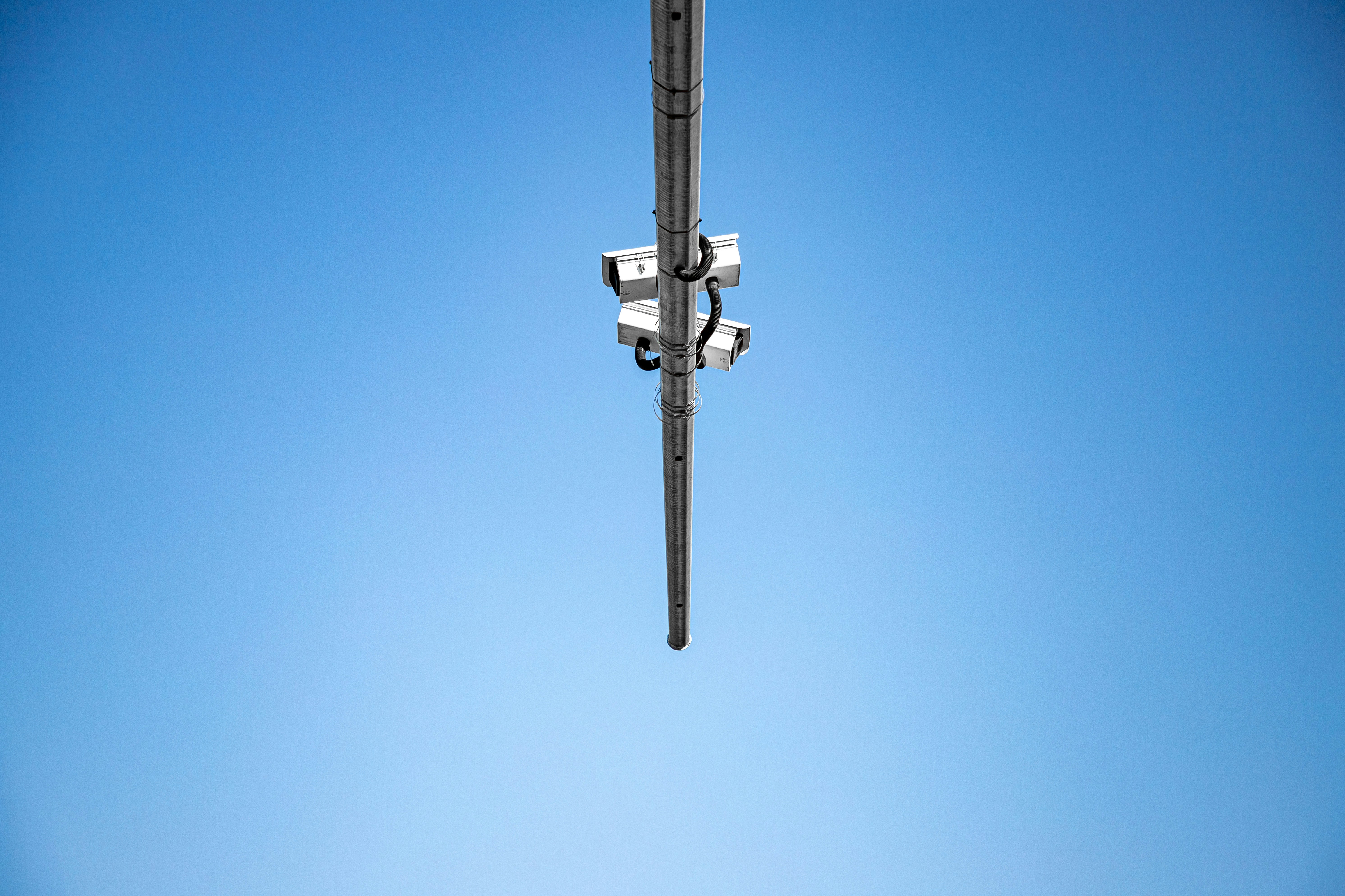 Skyward Sentinel: A lone camera mast piercing the blue