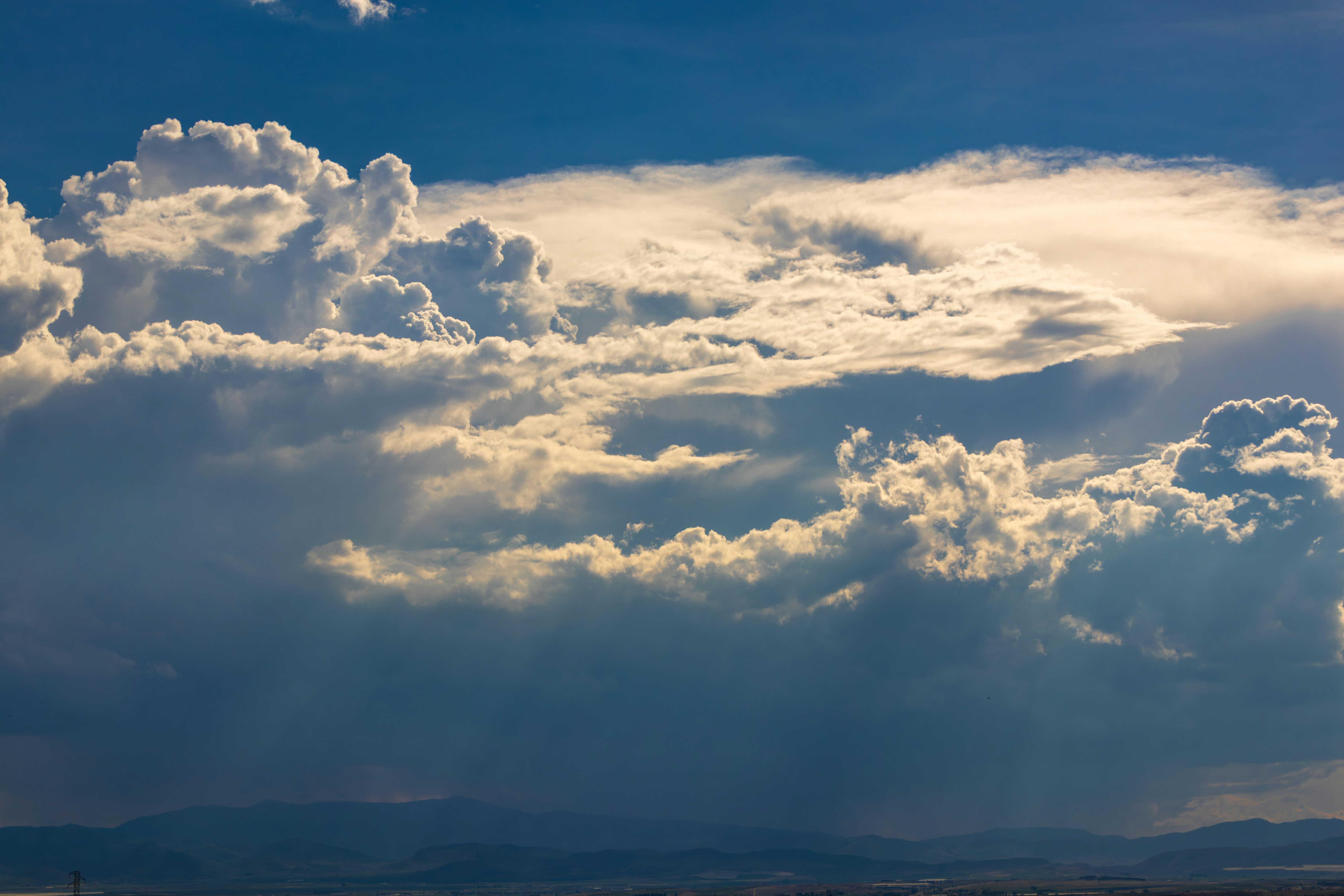 Sunlit Cloud Cathedral Over a Quiet Horizon