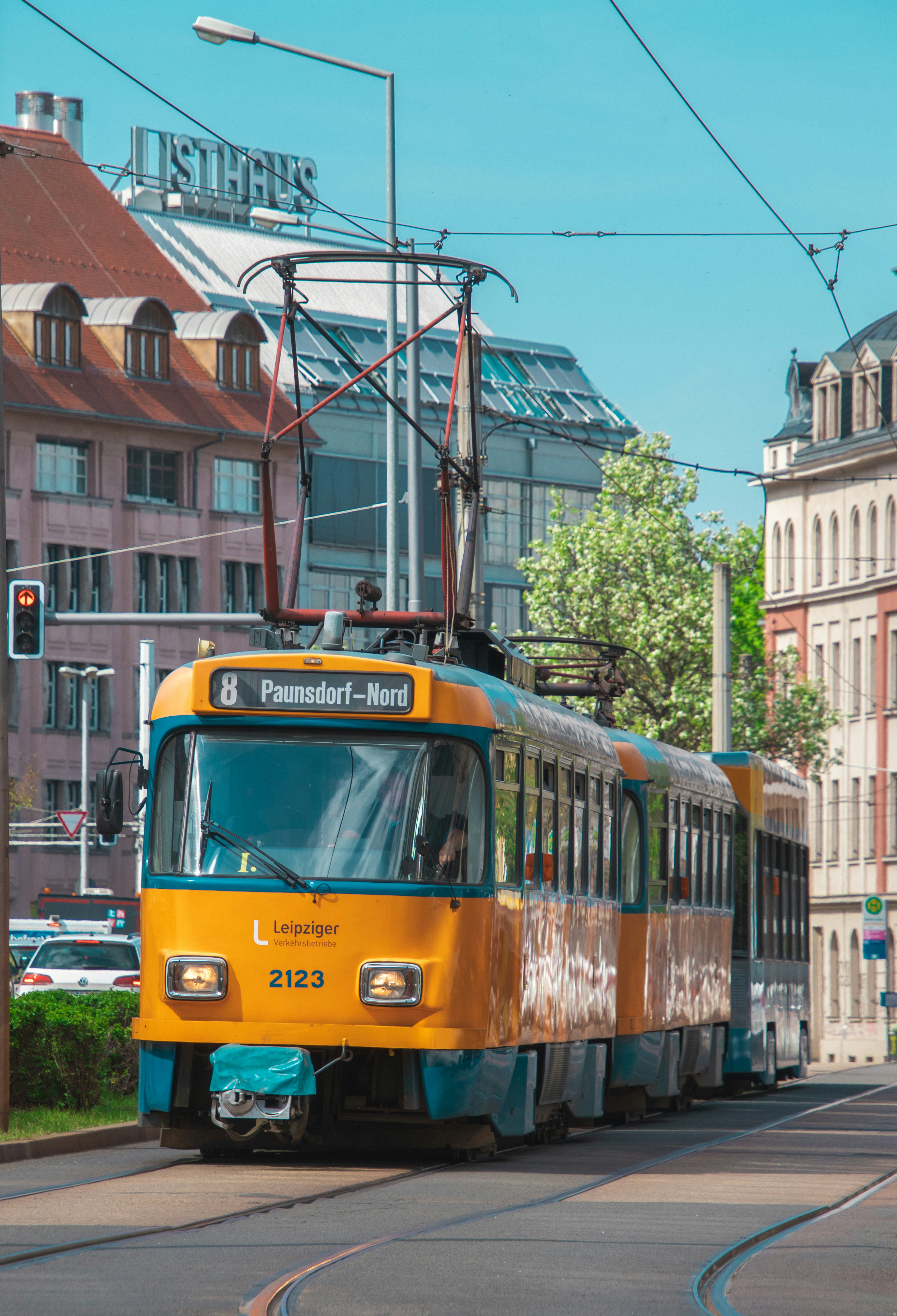 Yellow Tram Rides Through a Sunlit Urban Corridor