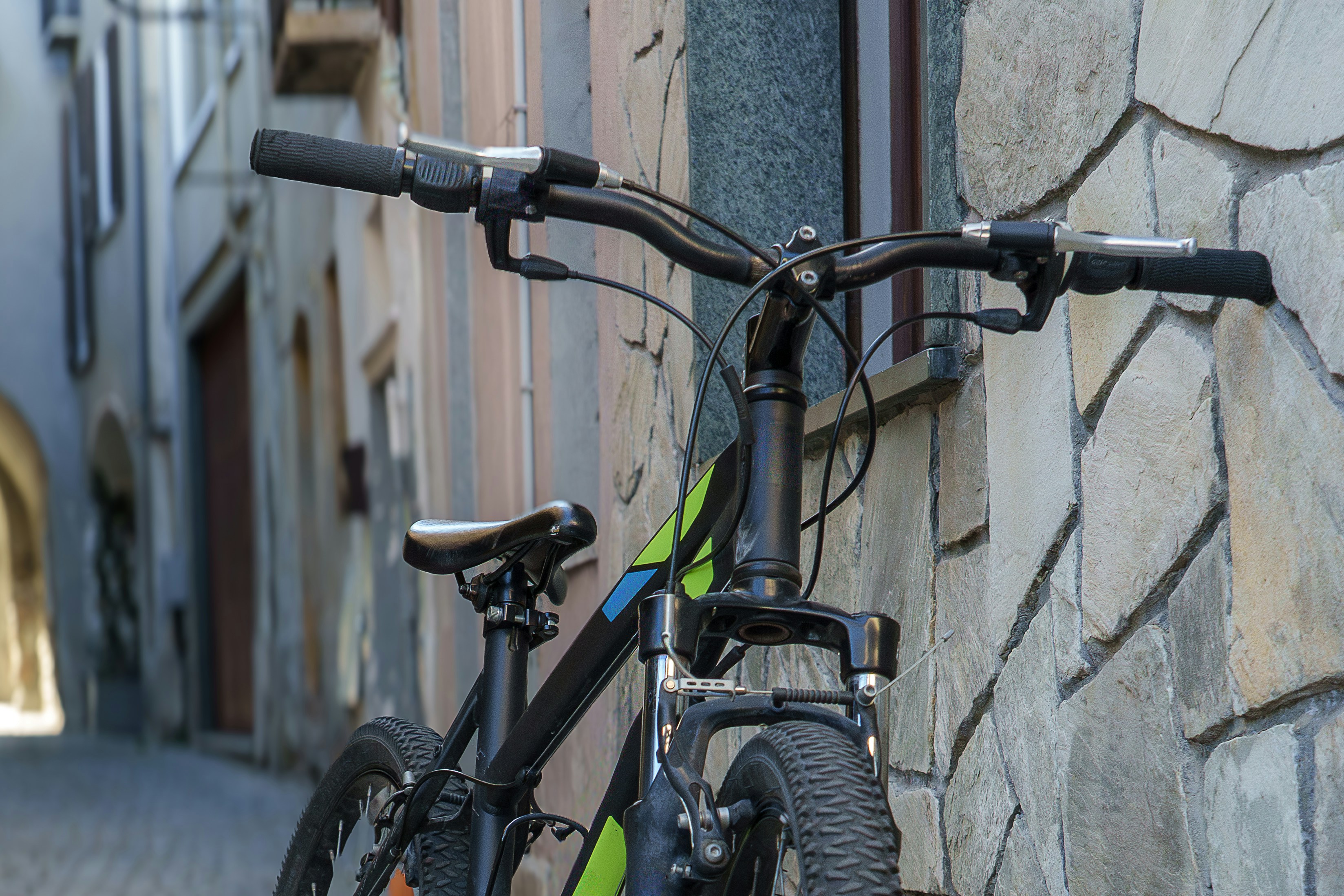 Urban bike leaning into a stone wall in a narrow alley