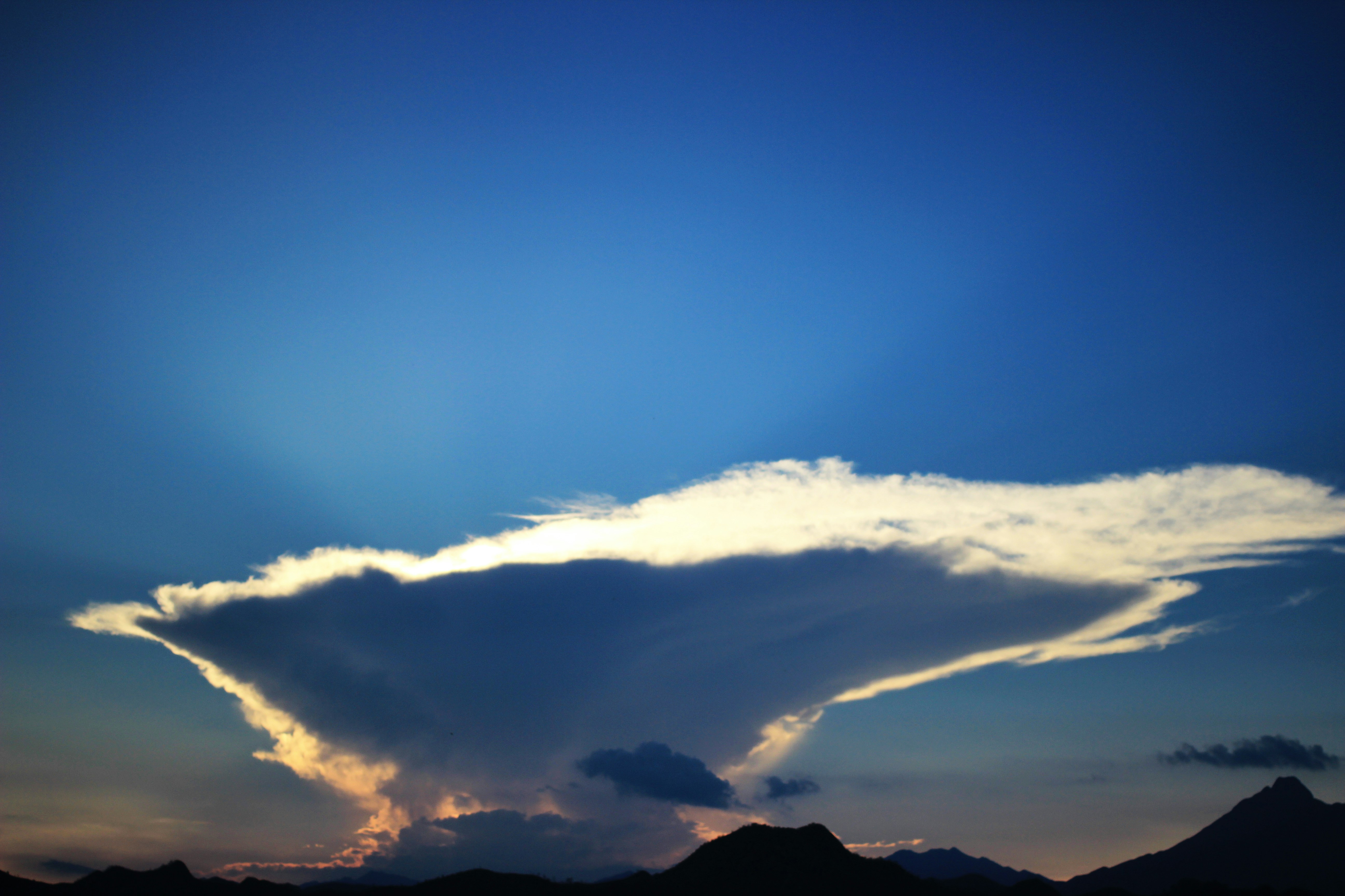 Silhouette Horizon Beneath a Cloud-Crowned Evening