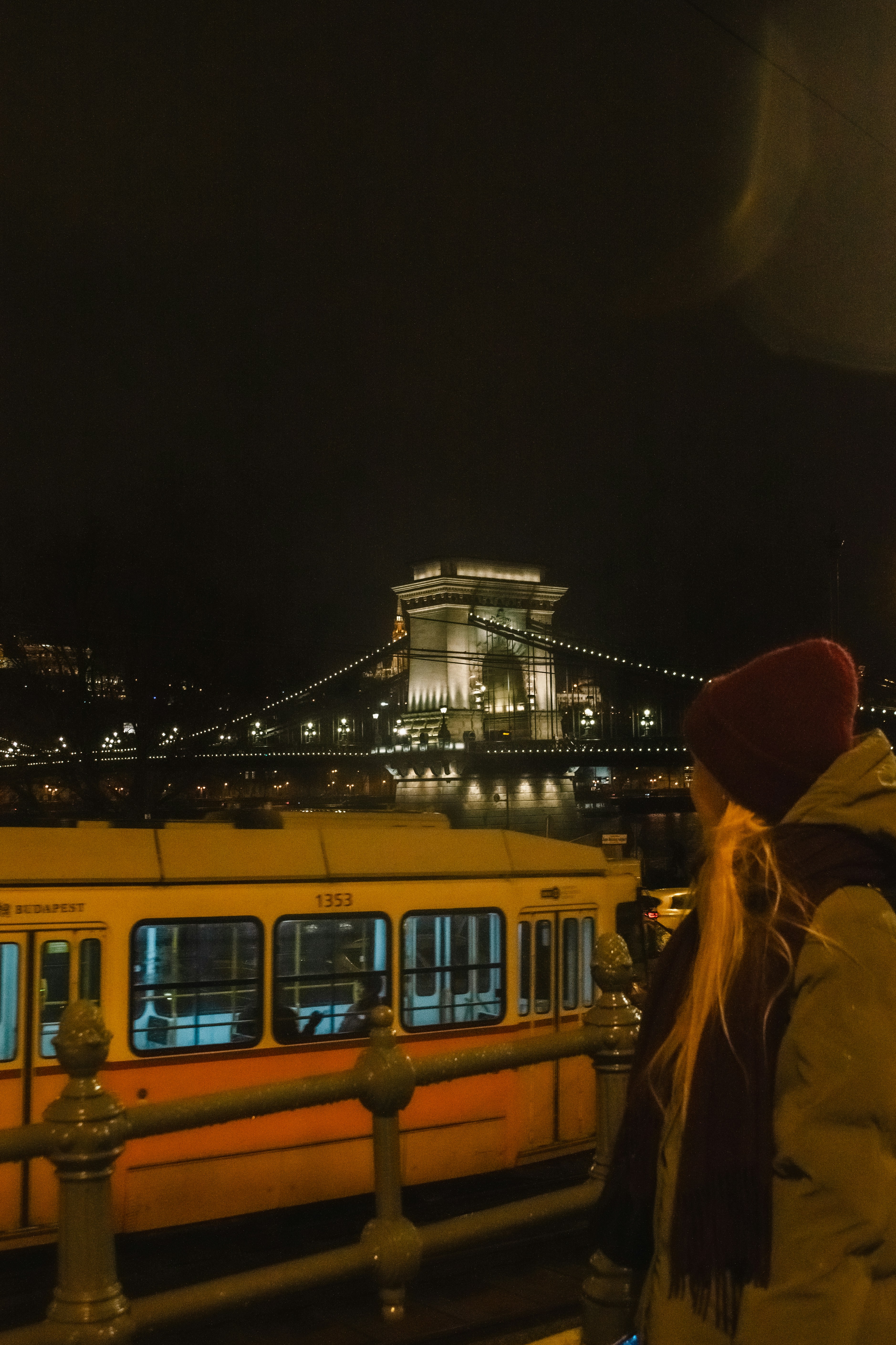 Nighttime Confluence: A Woman by the Riverbridge and Neon Lights