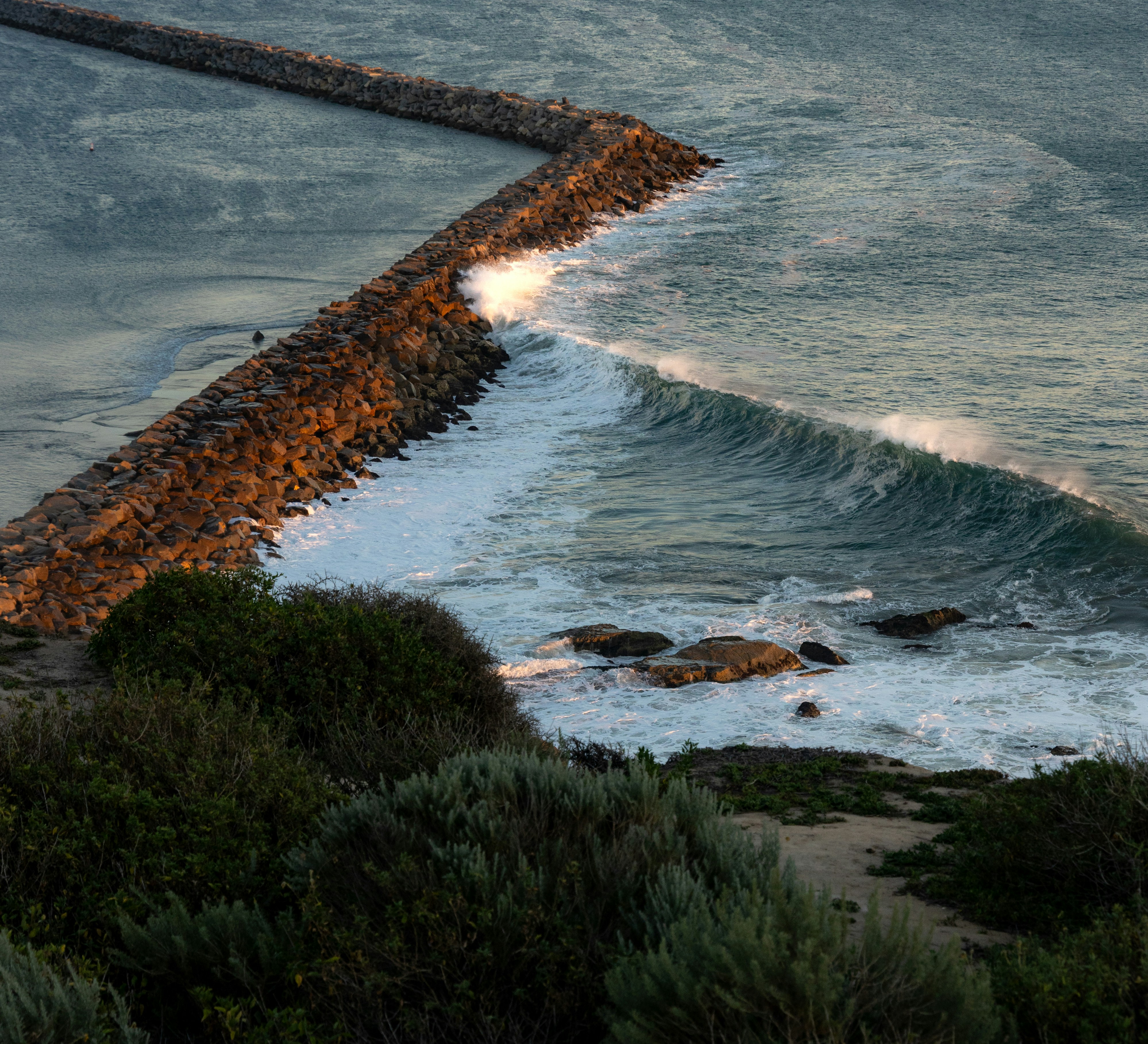 Stone Breakwater Reaching into a Quiet Break