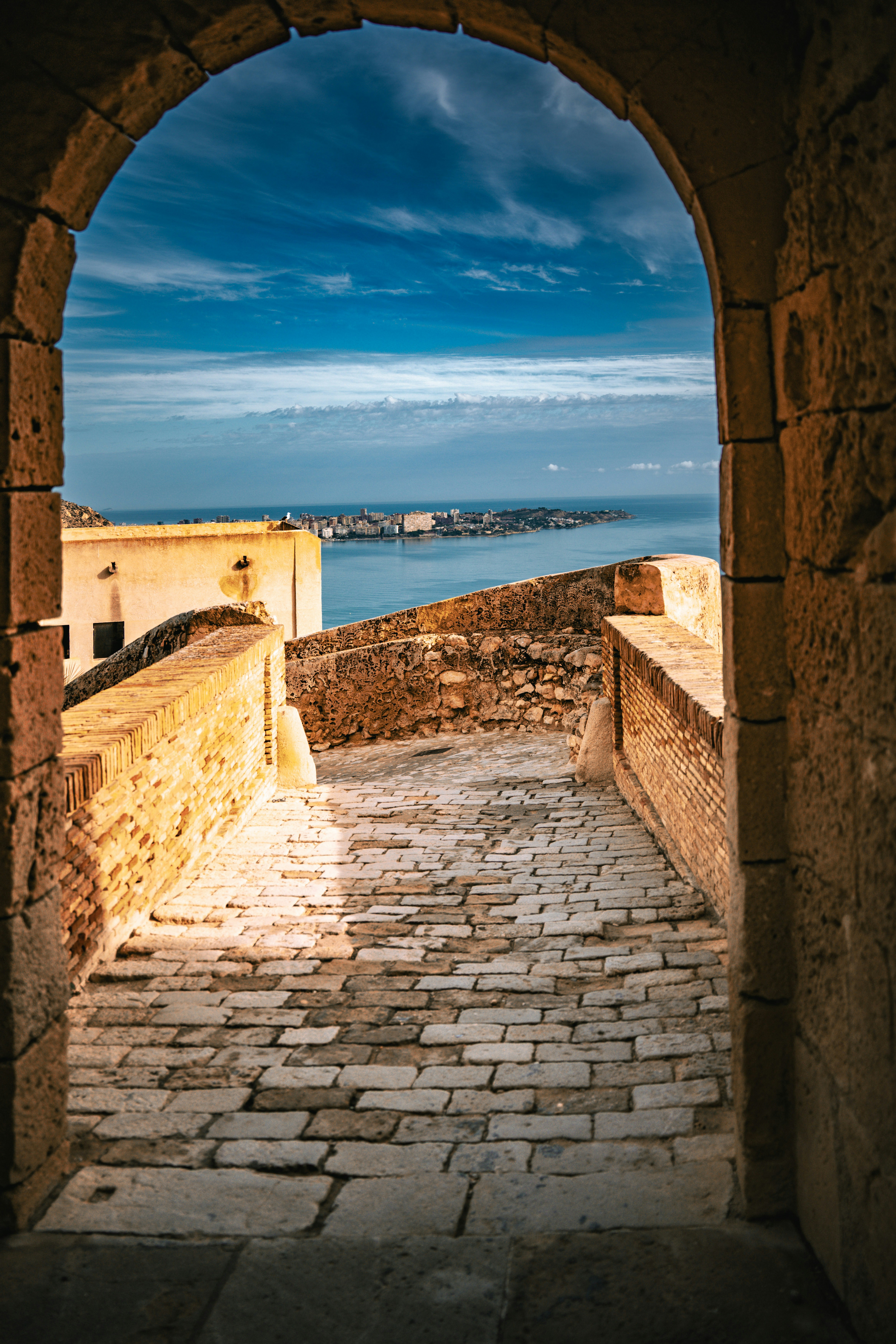 Azure Promenade: Sea View Framed by Ancient Archway