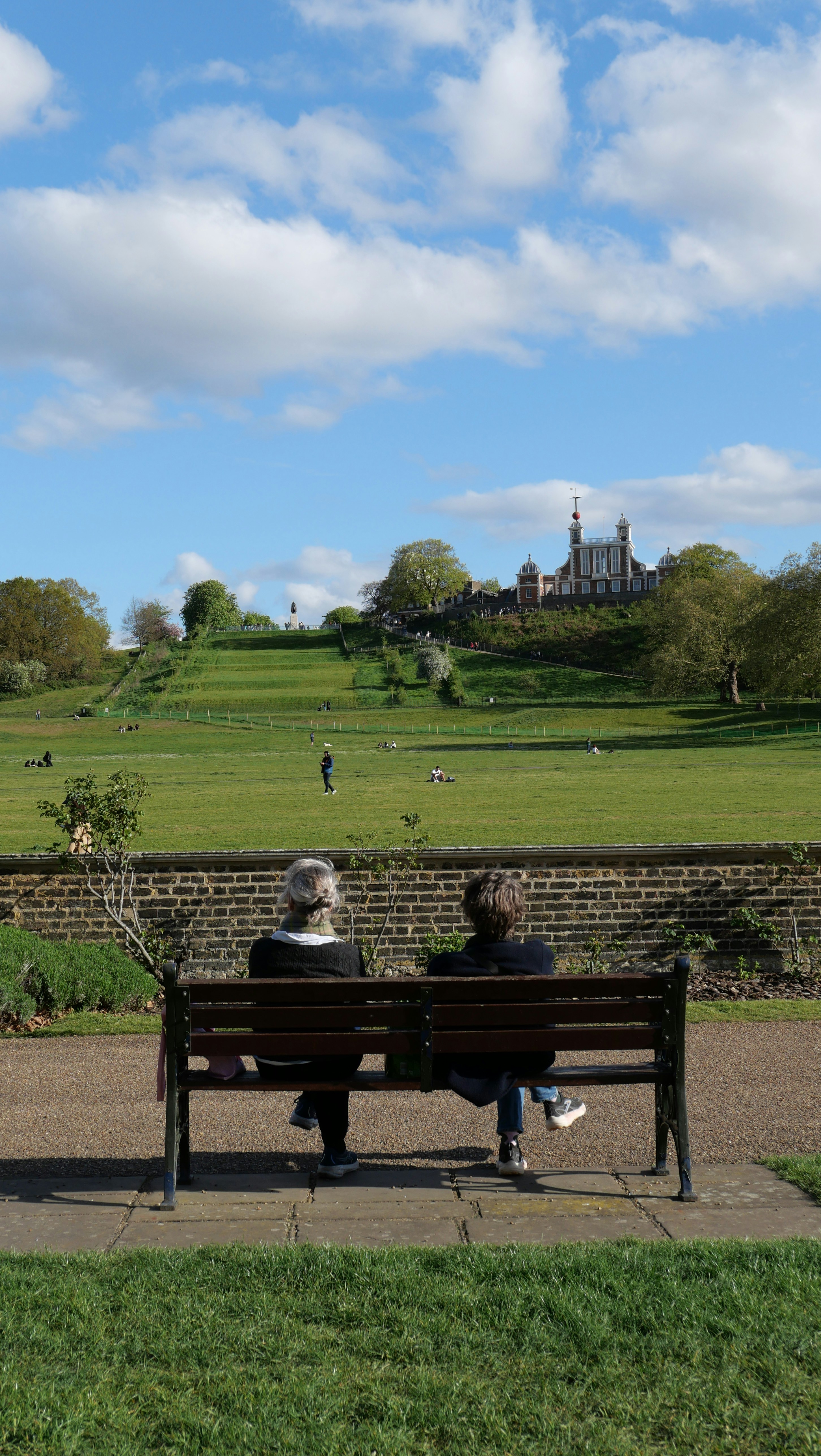 Couple on a Park Bench Gazing Toward the Hilltop Estate