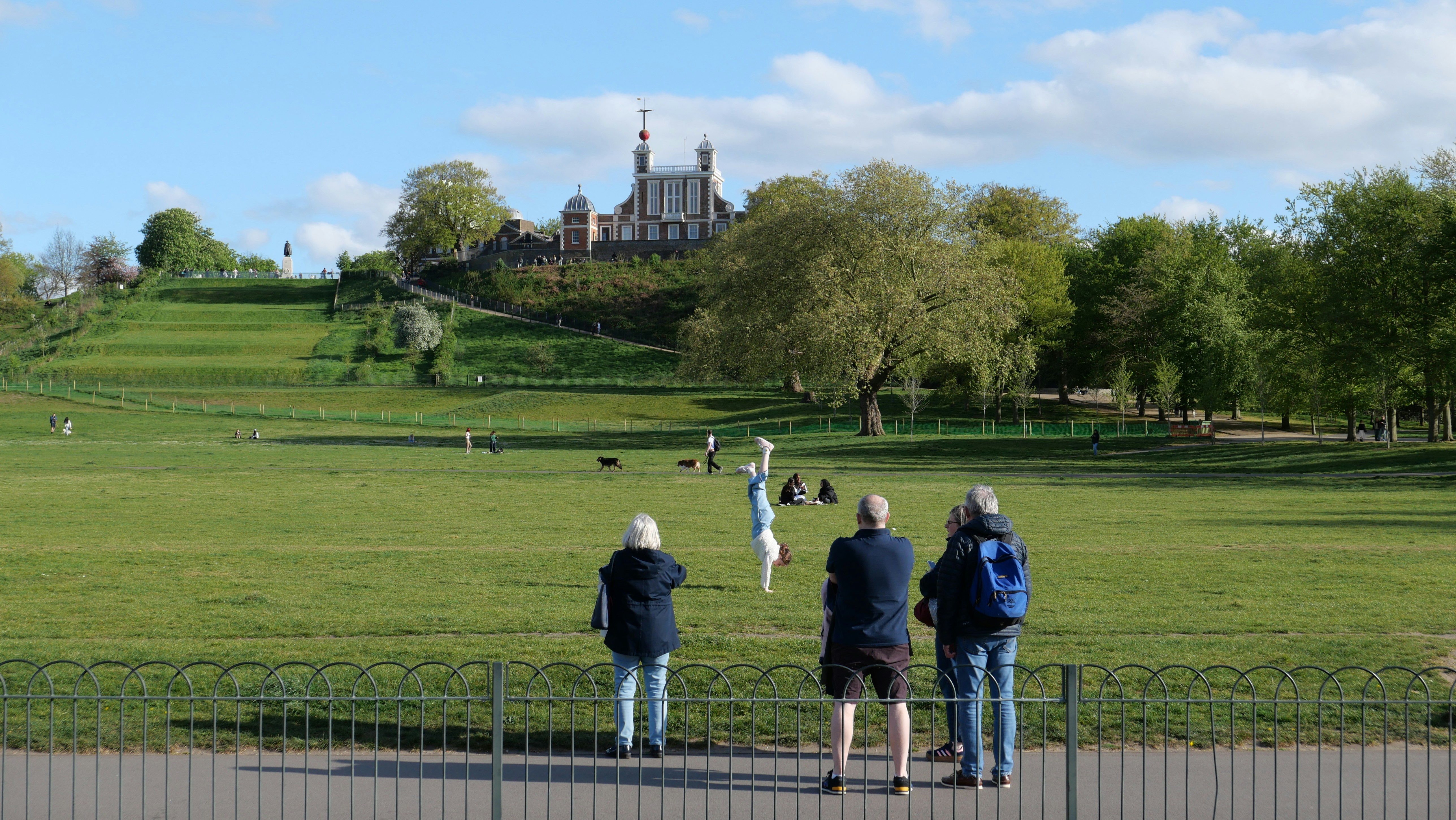 Parkside Portrait: Visitors Watch a Sculptural Acrobat on a Bright Hill