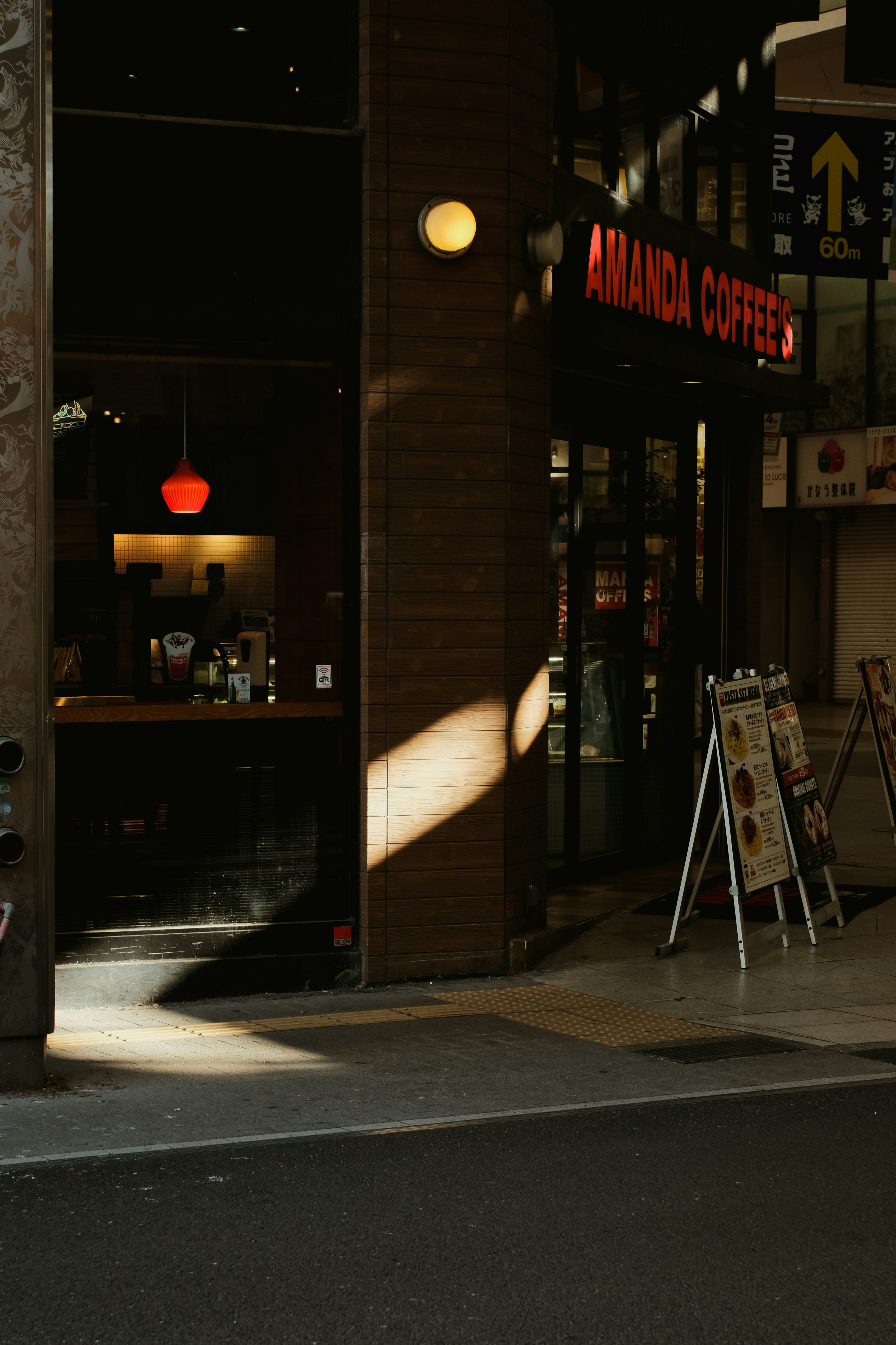 Neon Sign, Warm Light, and Shadowed Café Façade