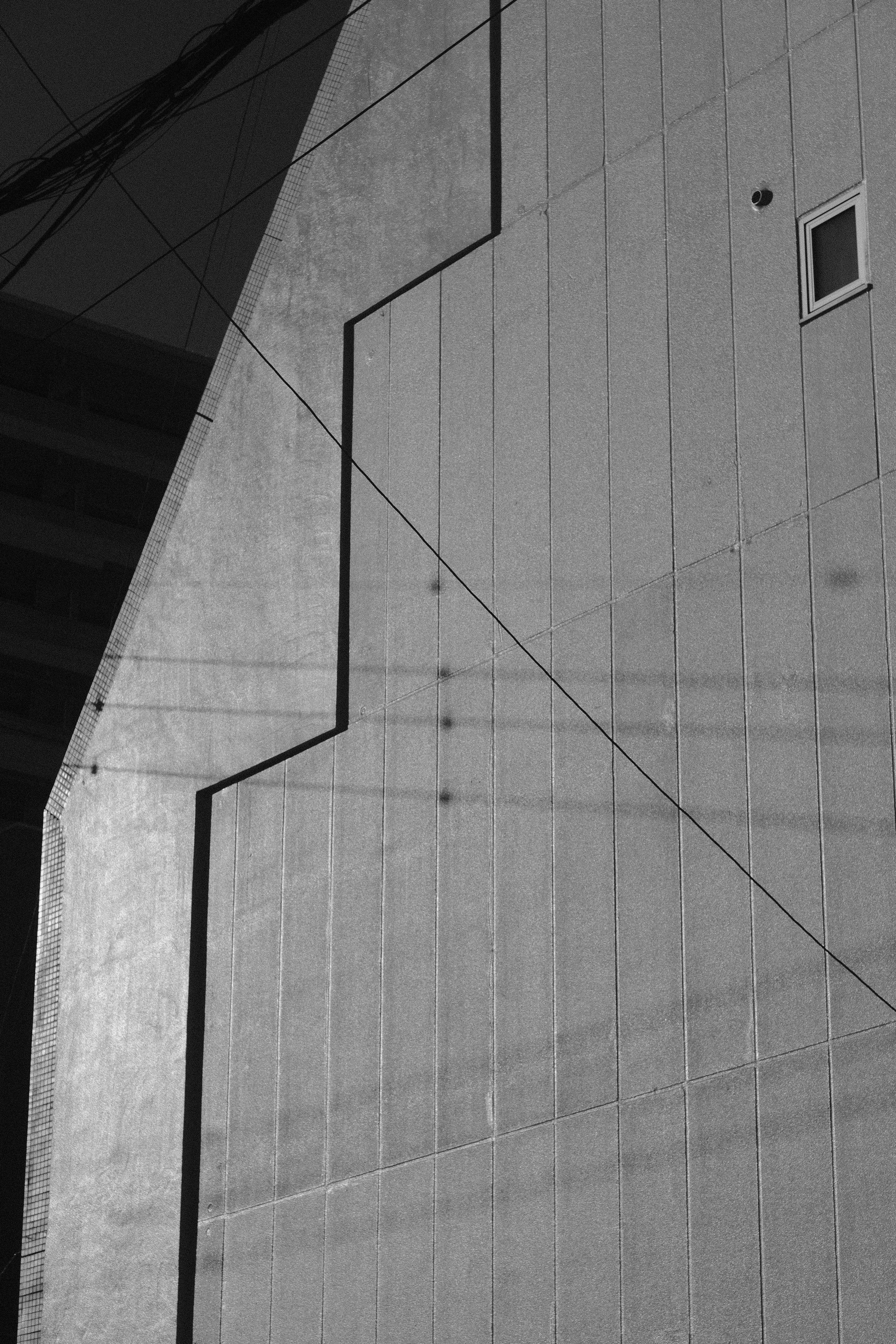 Geometric Facade: Intersecting Lines on Monochrome Wall