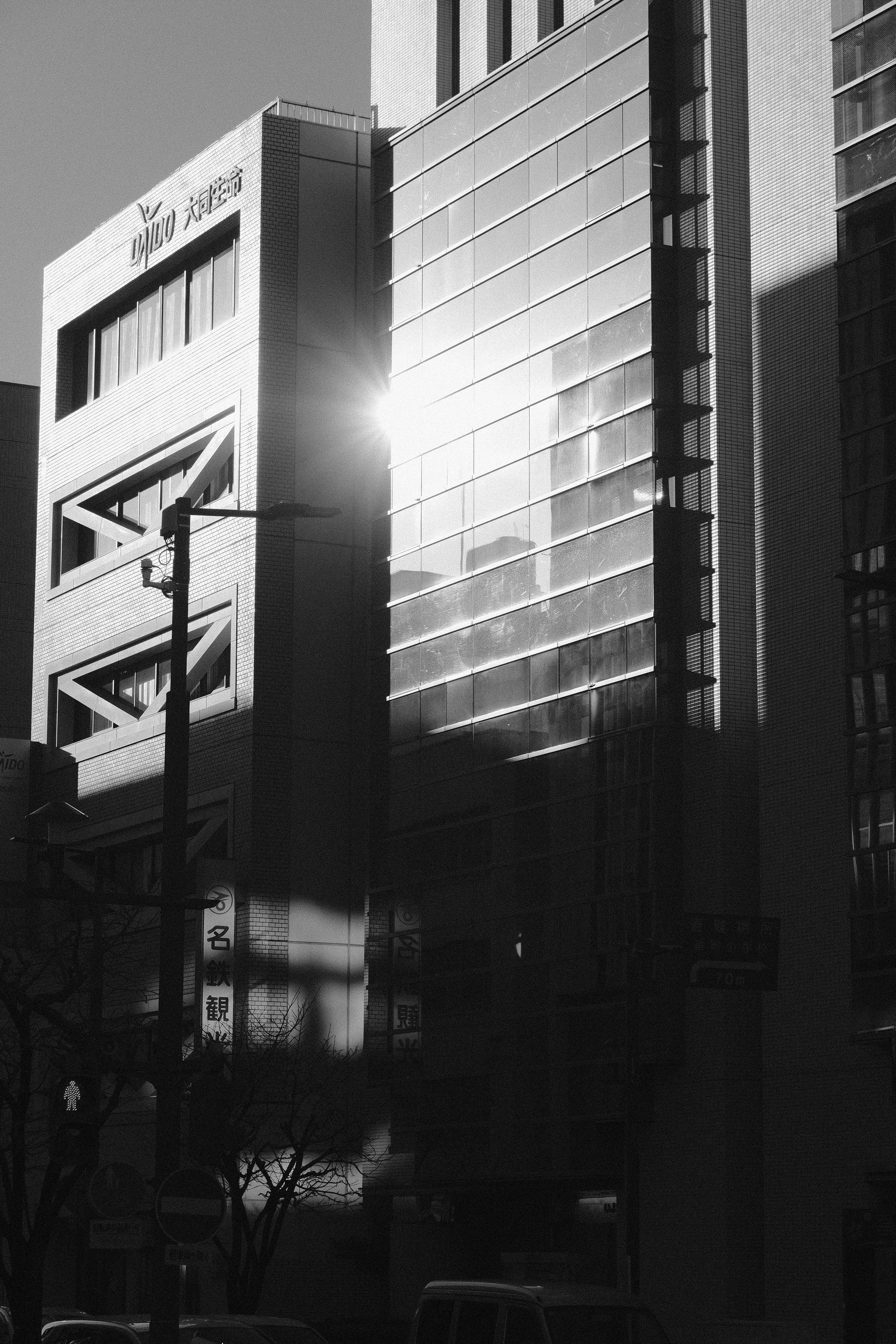Sunlit Glass Facade Behind the Shadowed Street