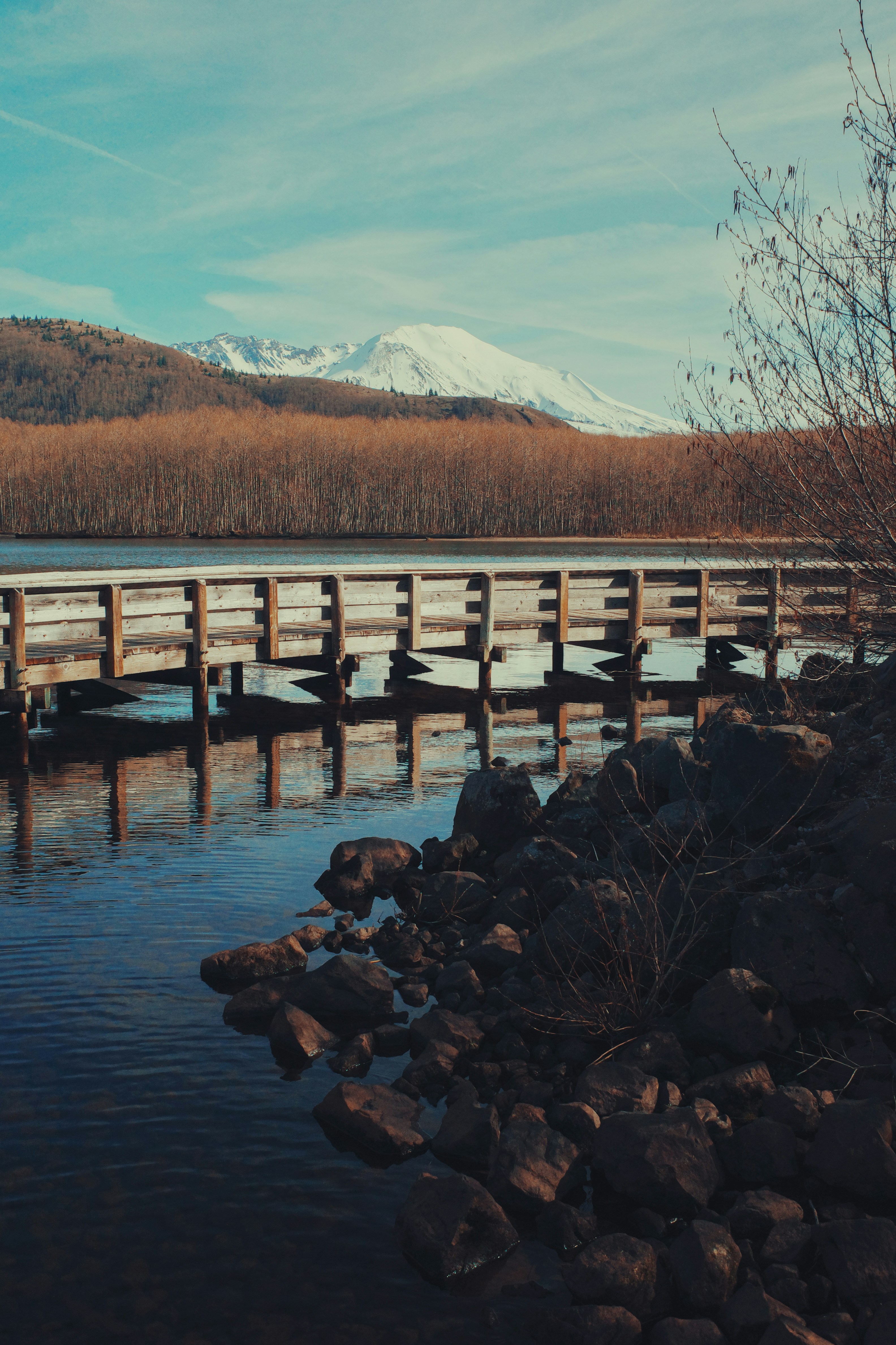Wooden Pier Over Calm Fjord with Snow-Capped Peaks