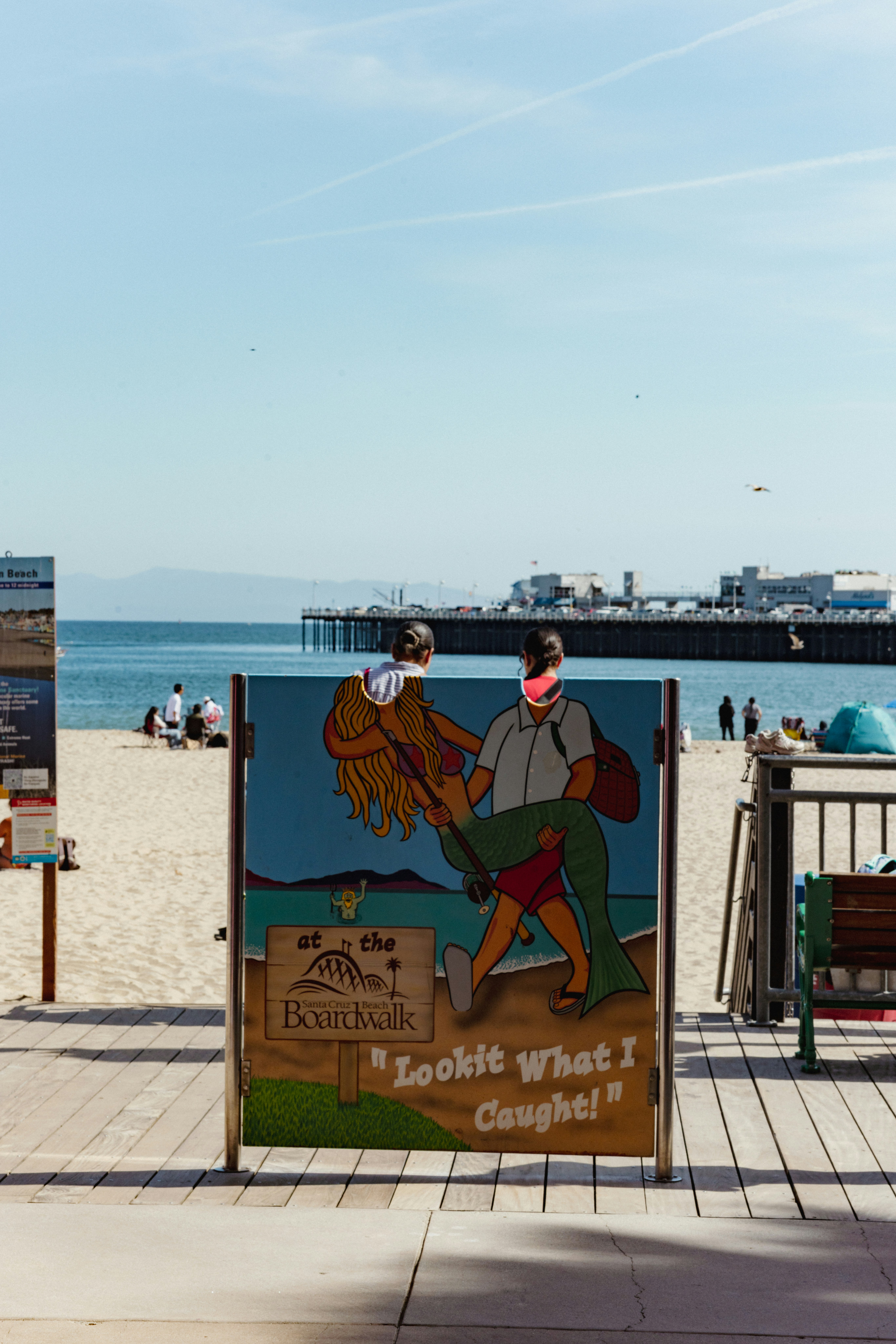 Boardwalk Encounter: A Bright Sign Framed by Beach and Pier