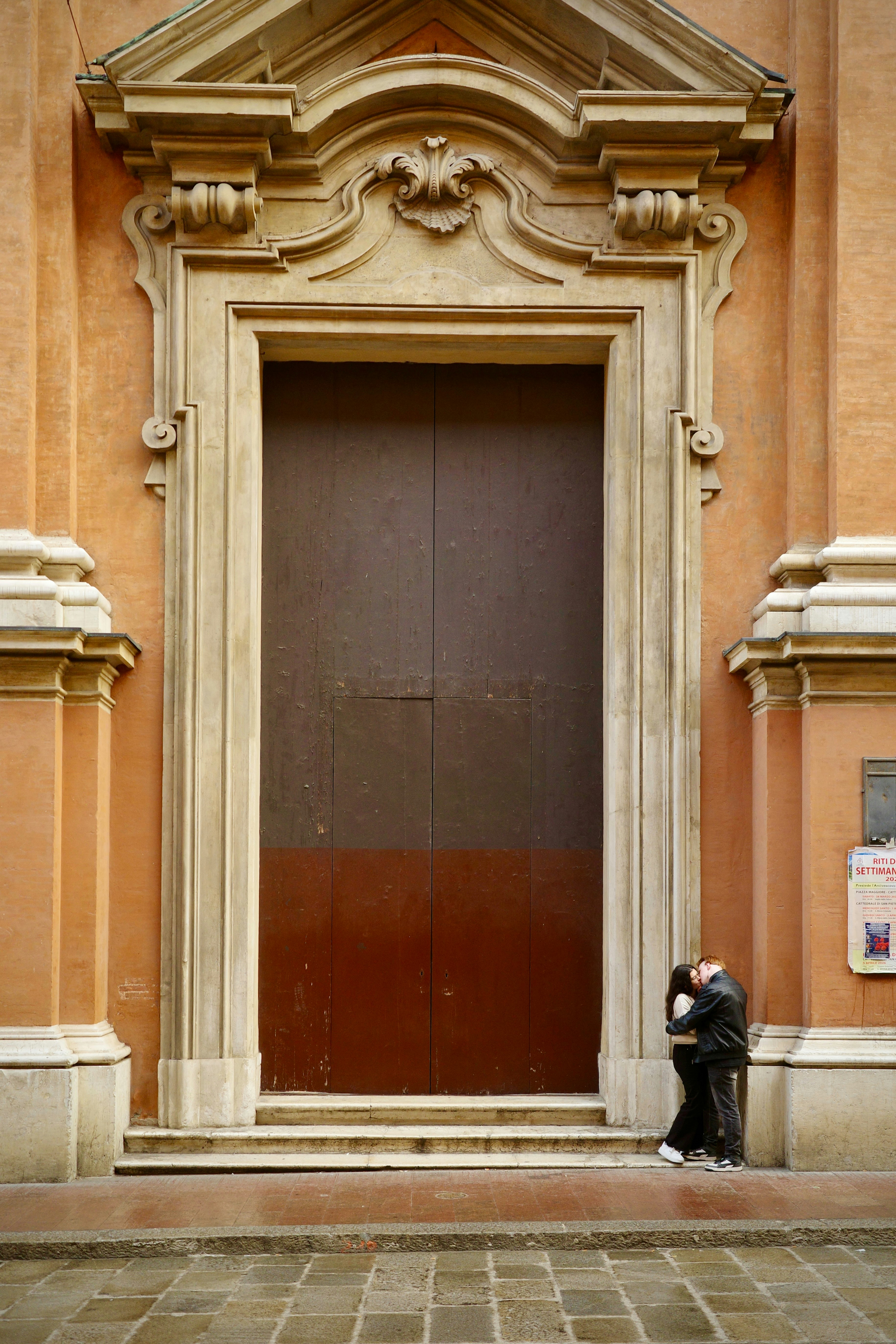 Couple in Shadowed Threshold: A Moment Beside a Grand Ornate Door