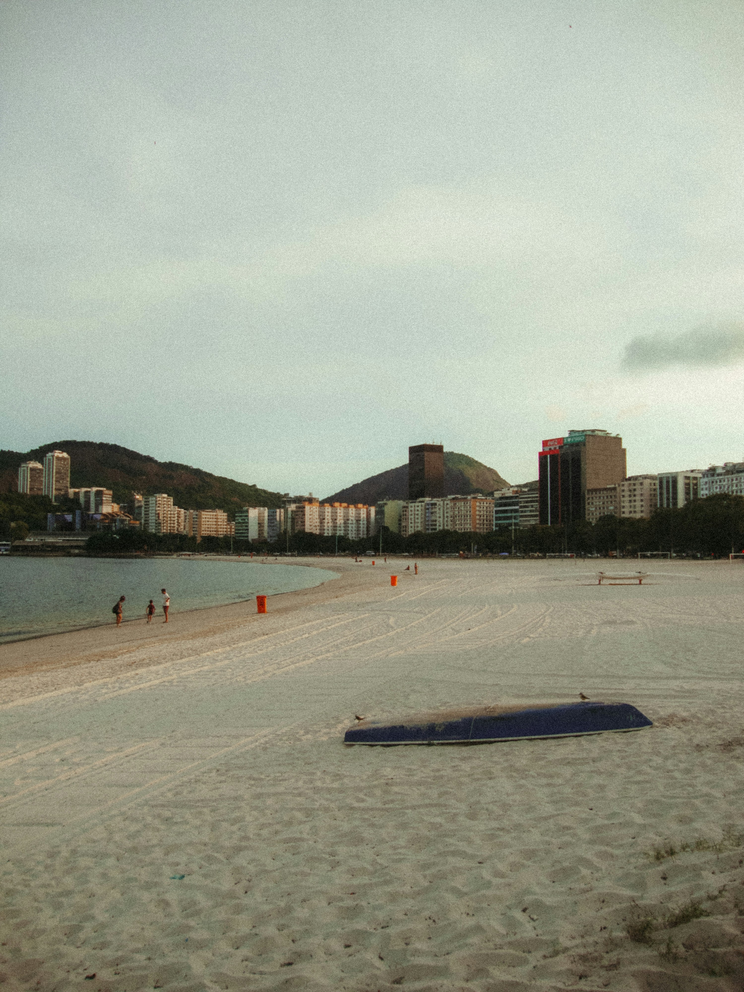 Quiet Urban Beach at Dusk: Cityscape Meets Sand and Sea