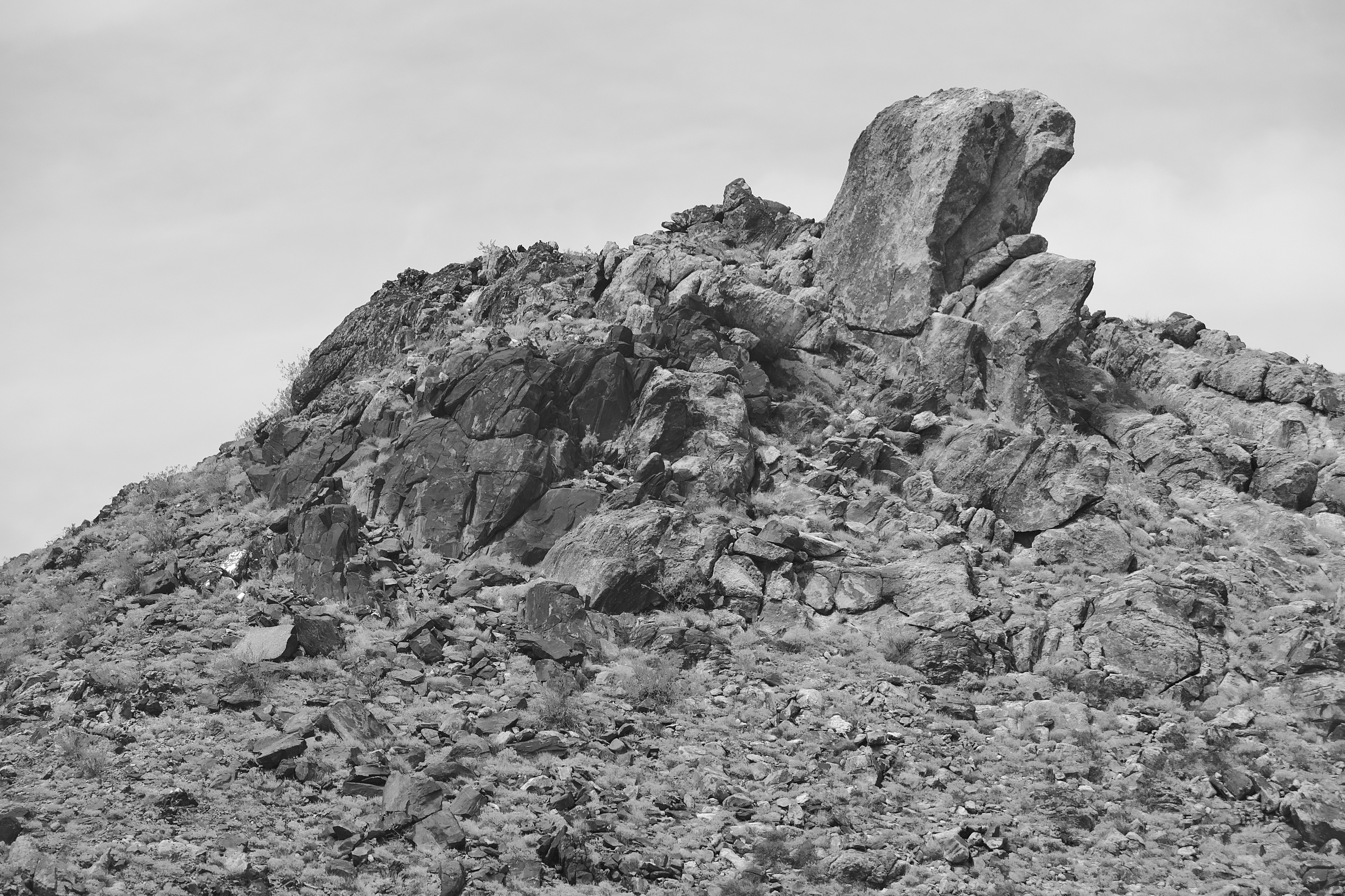 Rugged Quartz: A Lone Rock Sentinel Towers Over Grey Gravel